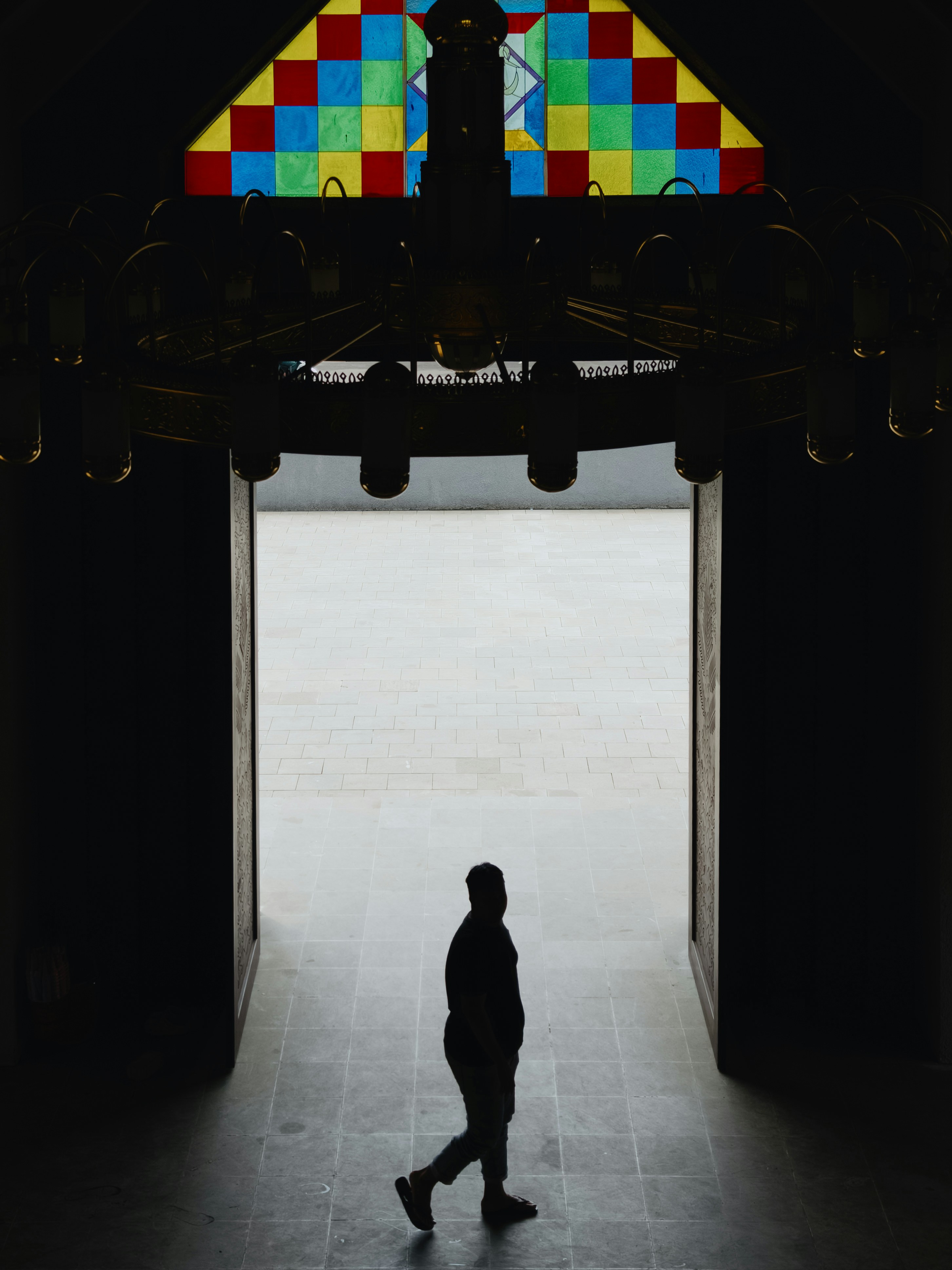 Silhouette in the Portal: A Quiet Walk Through Stained Light