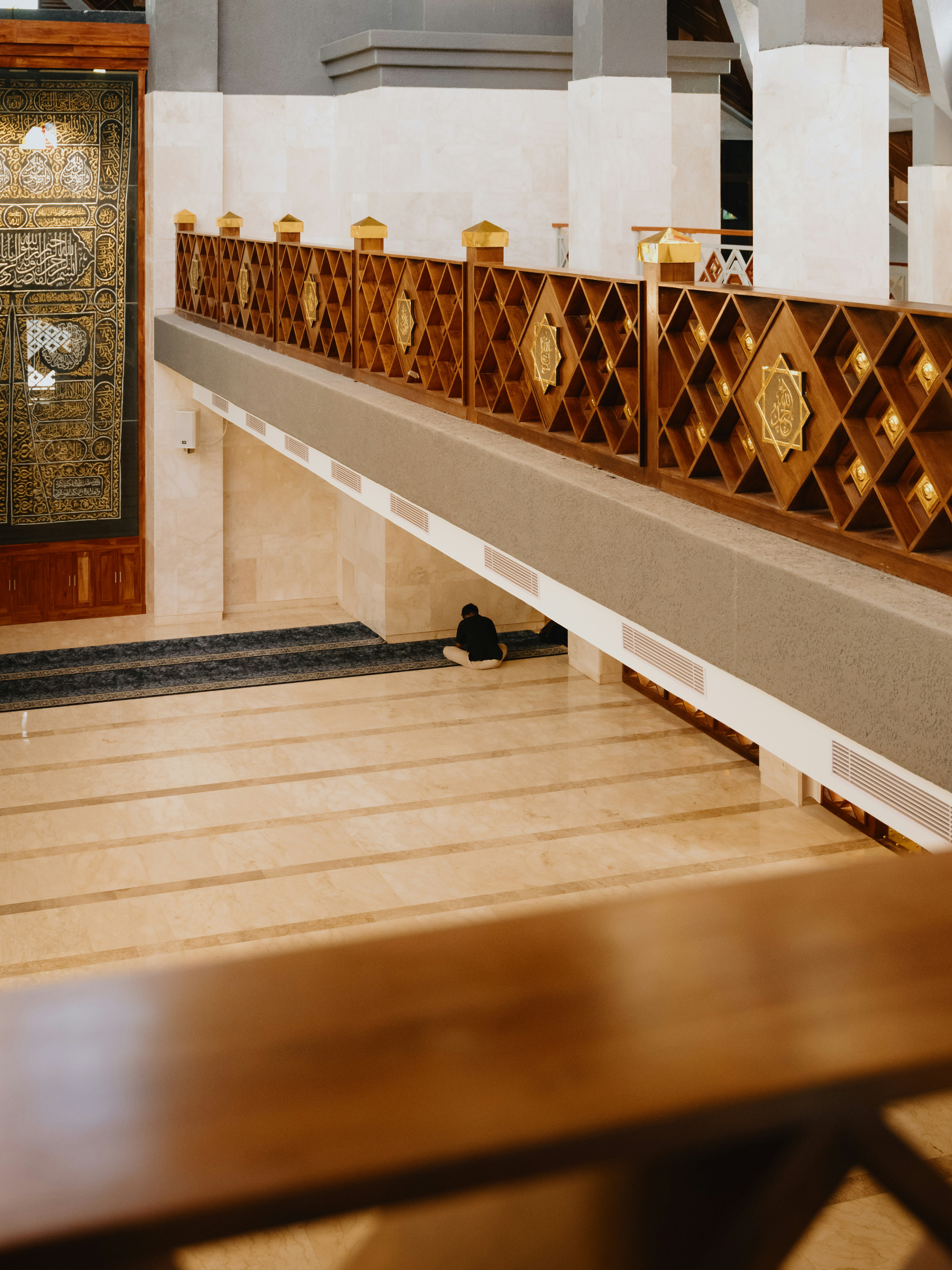 Quiet Corner: A lone figure beneath the ornate railing