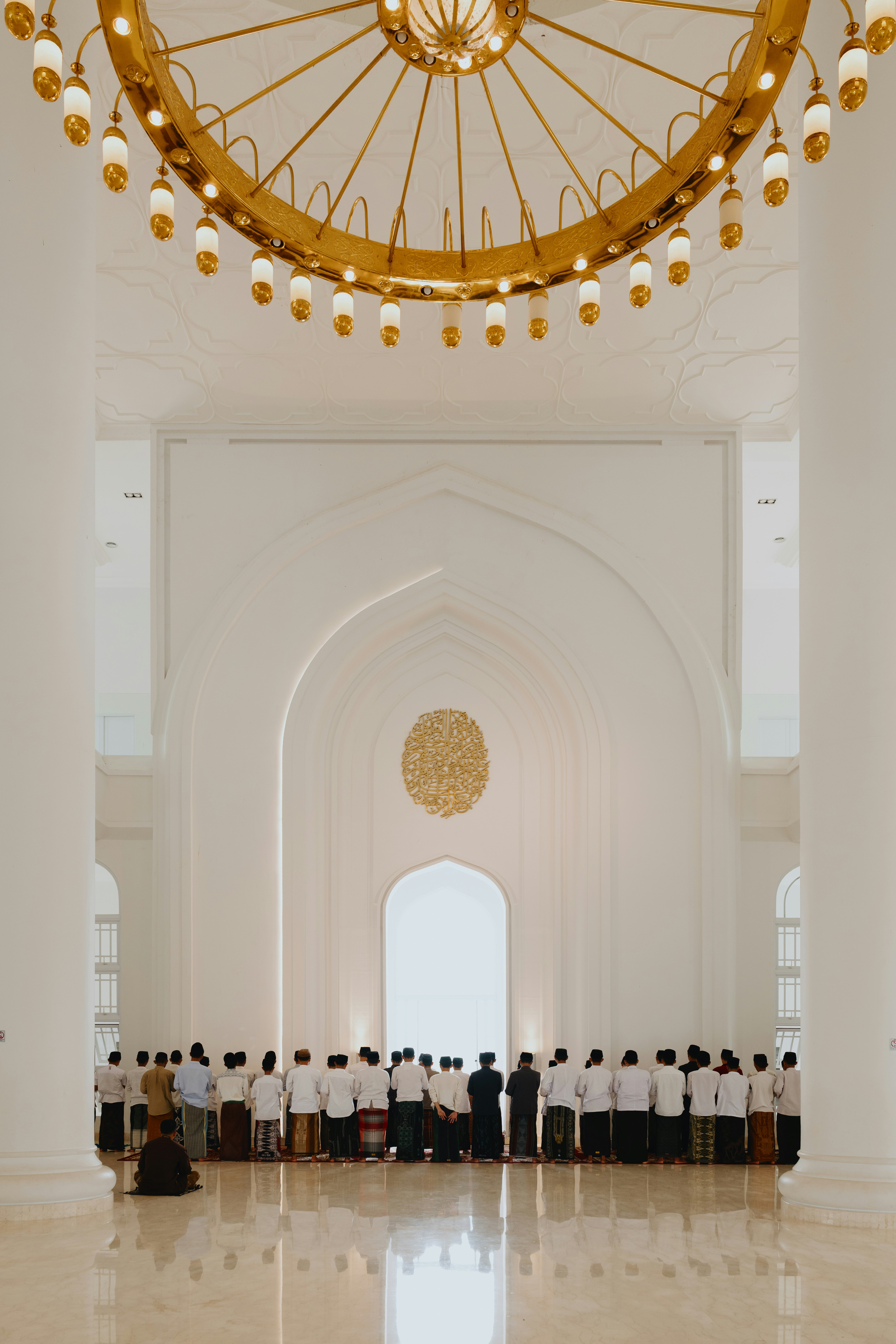 Symmetrical Cathedral Hall: A Sea of Attire Under a Golden Chandelier