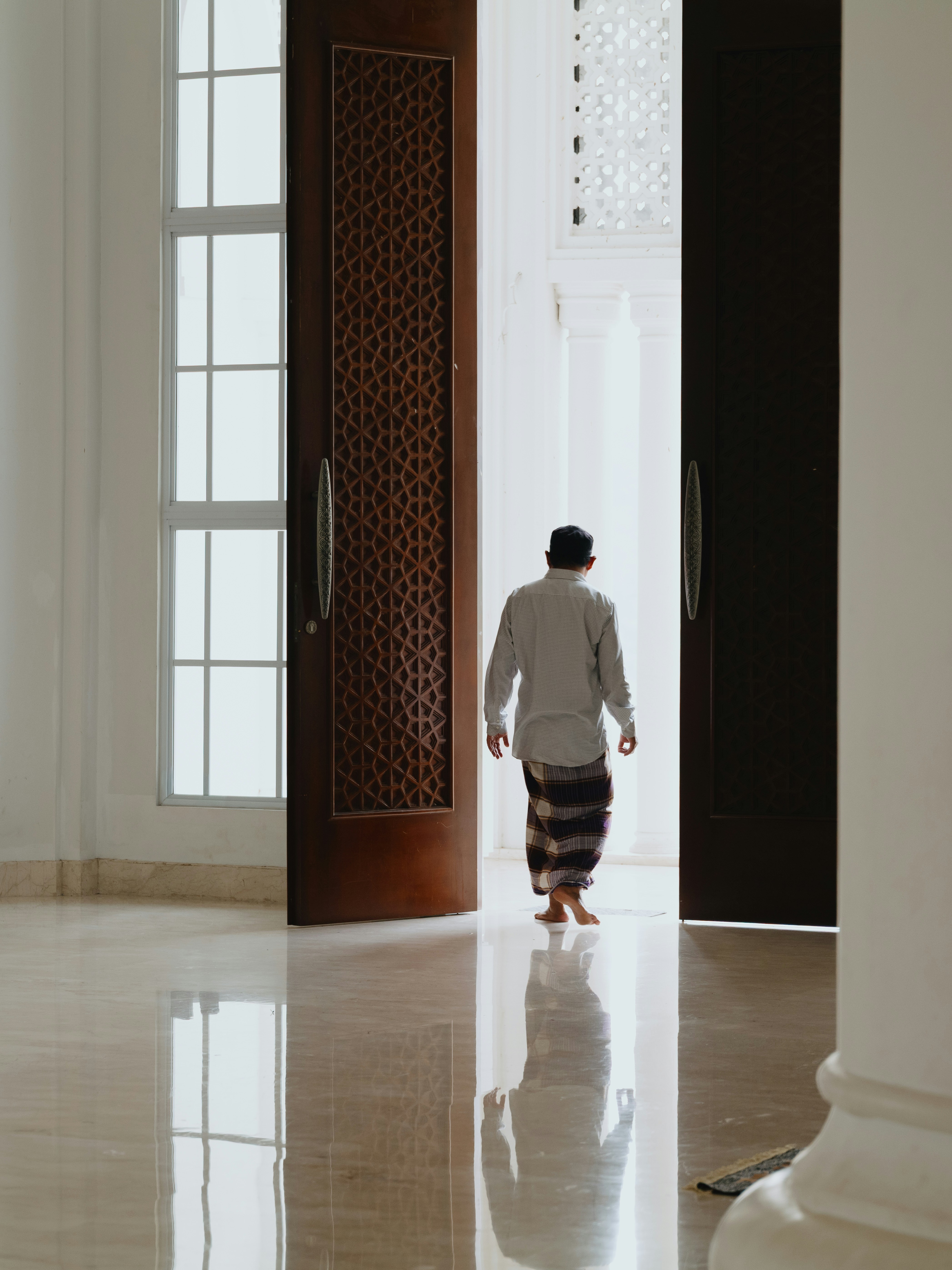 Threshold to Light: A Man Steps Through Ornate Doors