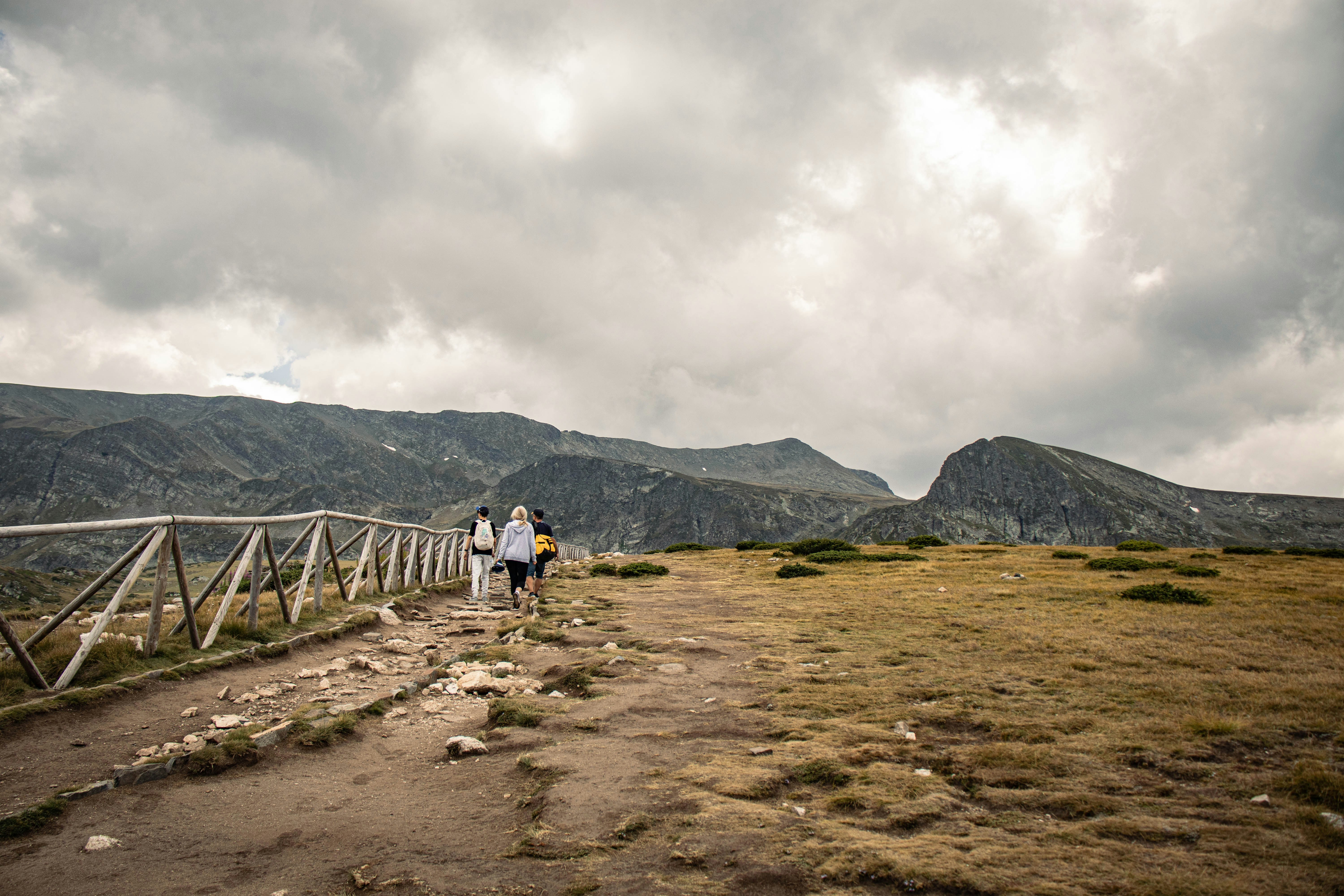 Hikers on a windswept ridge beneath brooding skies