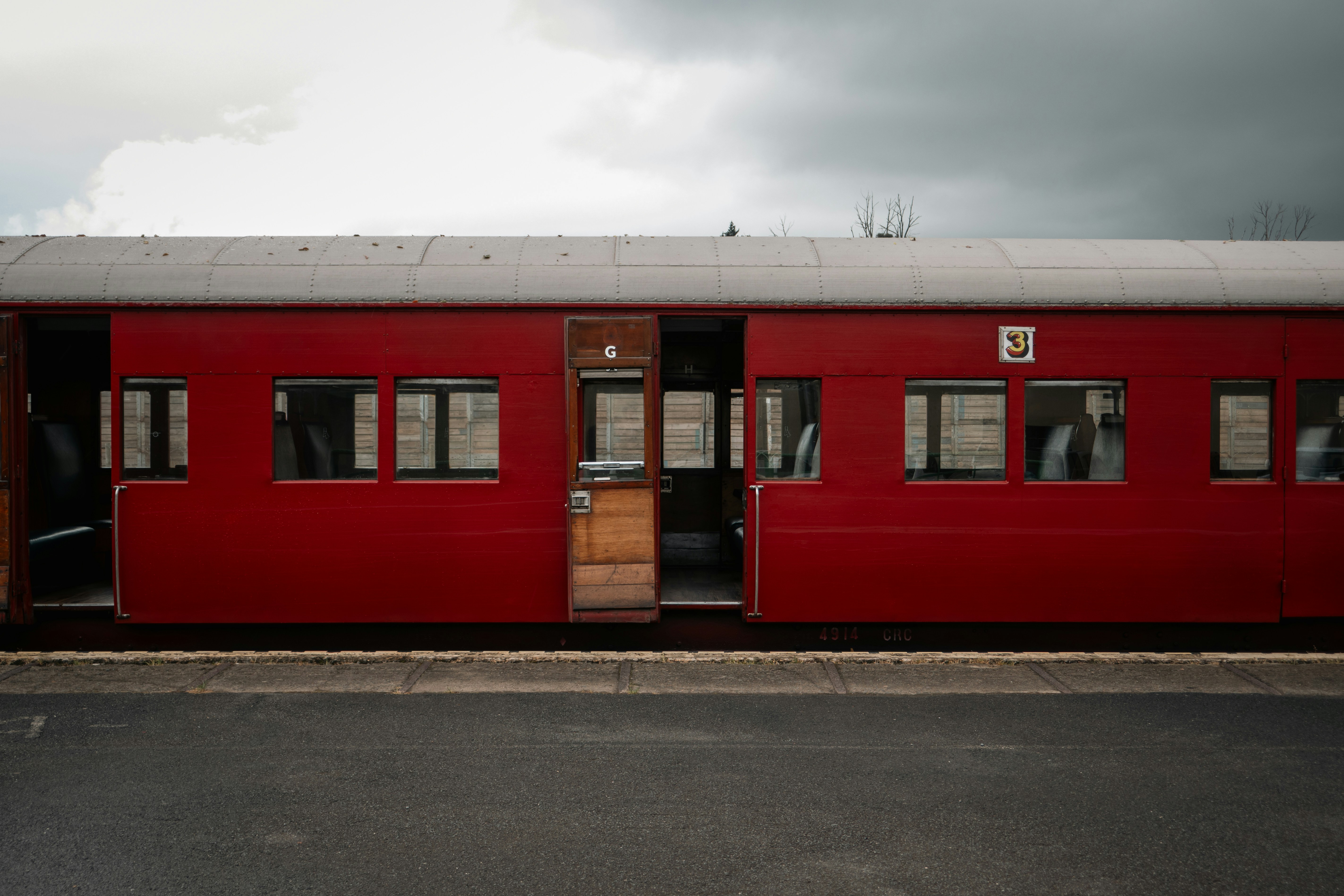 Red Railcar Quietly Stands At Platform’s Edge