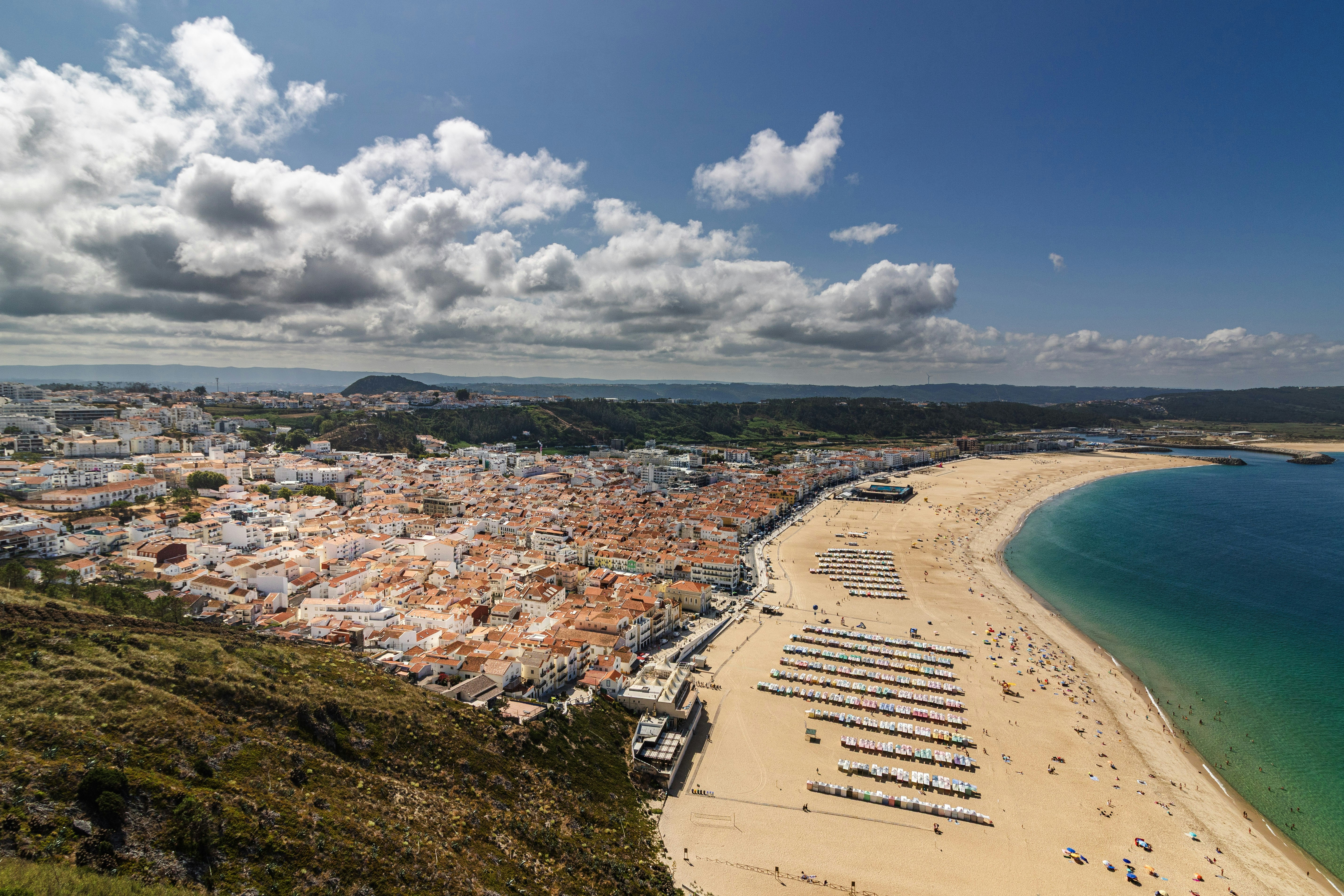 Aerial Vista of a Sunlit Coastal Village with Curving Beach