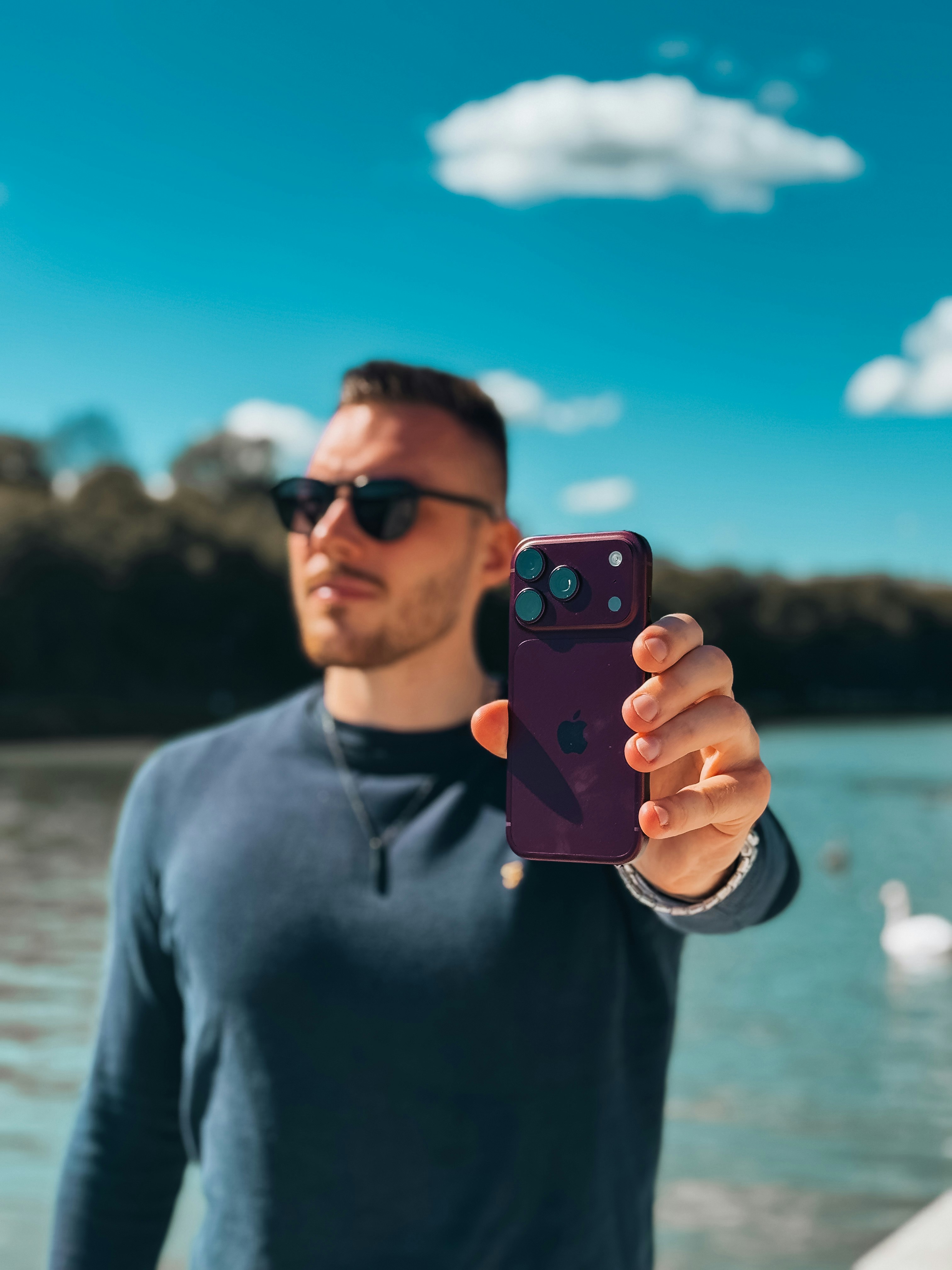 Liquid Sky in Hand: A Man Extends a Purple iPhone toward the Lens