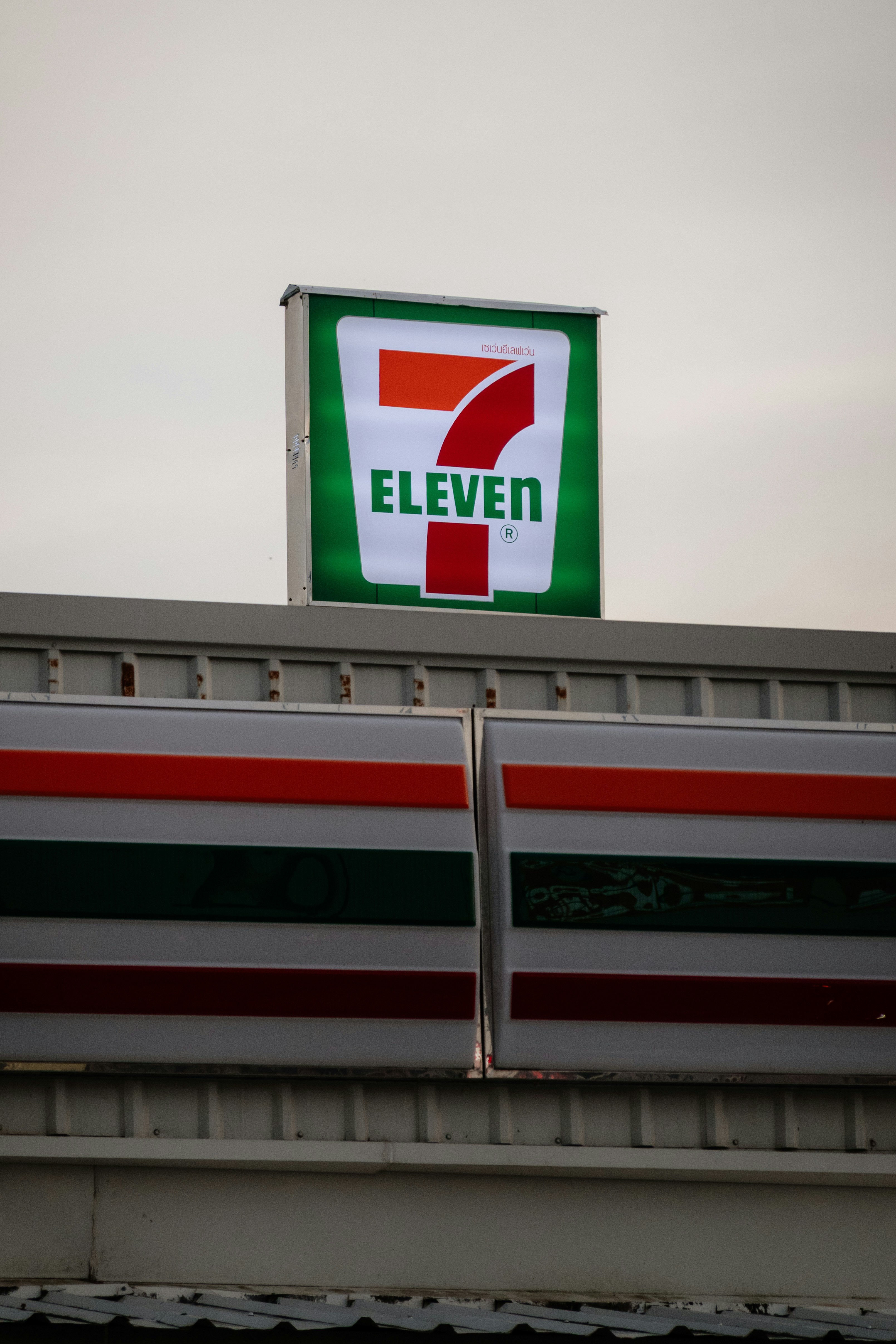 Signage Above a Ground-Level Barrier: 7-Eleven in Minimalist Light