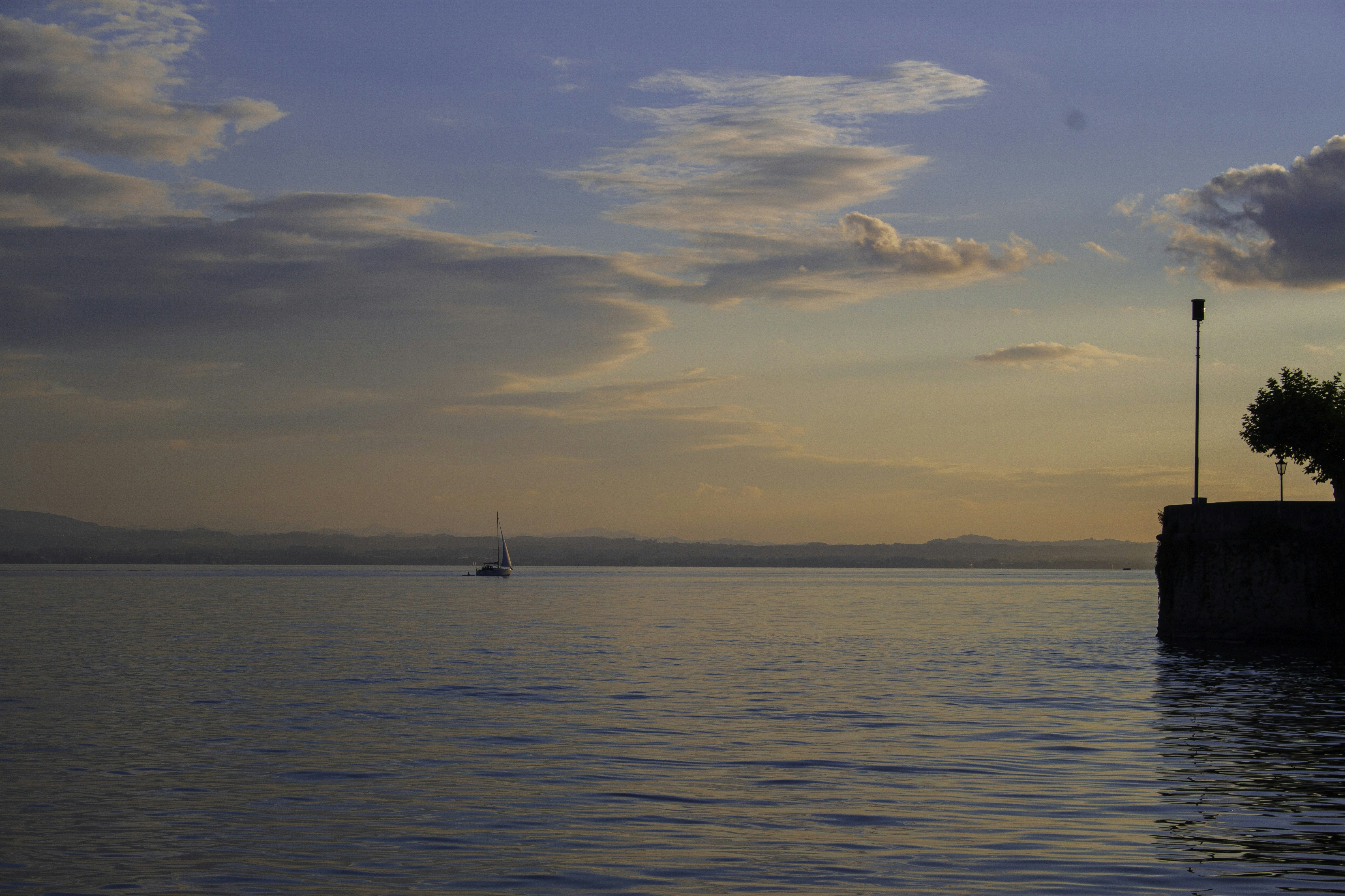 Horizon Bound: Calm Sea Meets Sunset Sky by the Pier