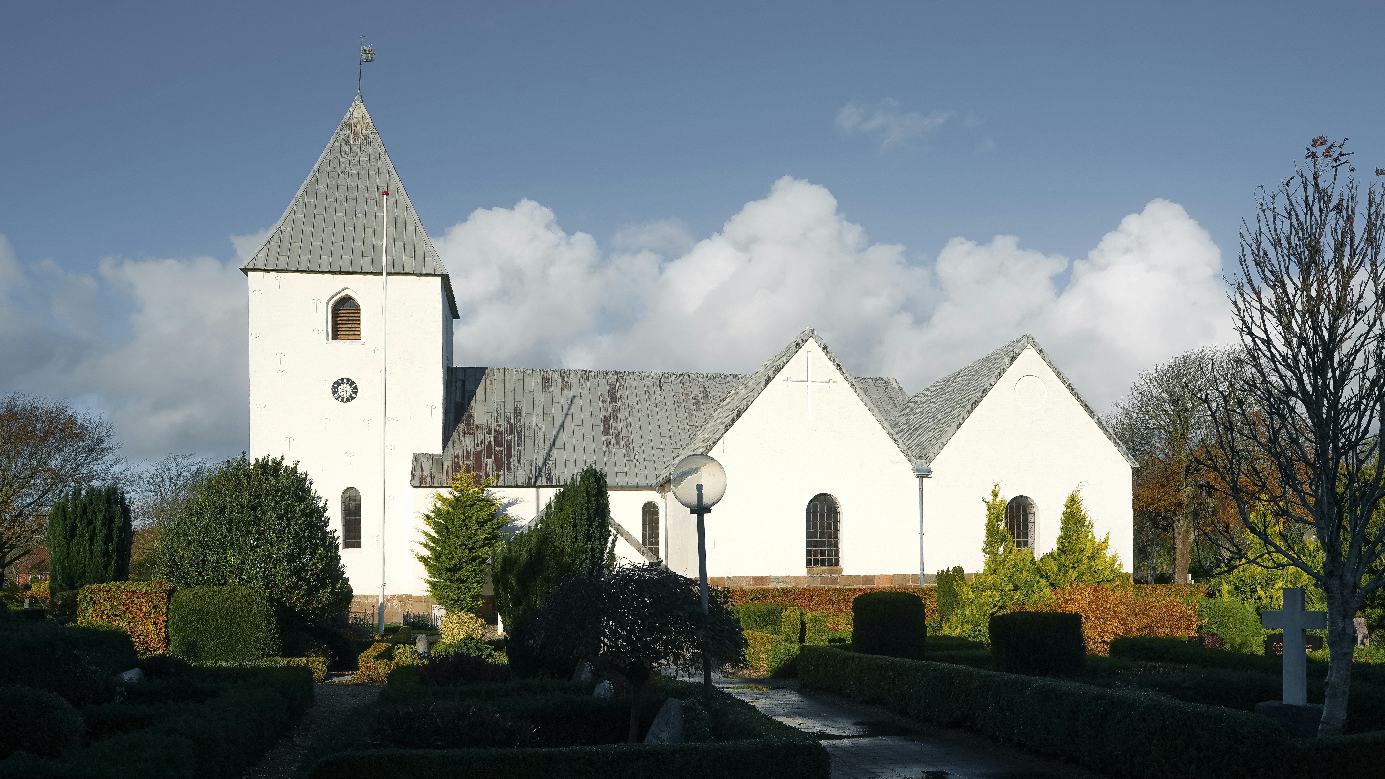 White Chapel silhouettes: A sunlit Anglican church under a blue sky