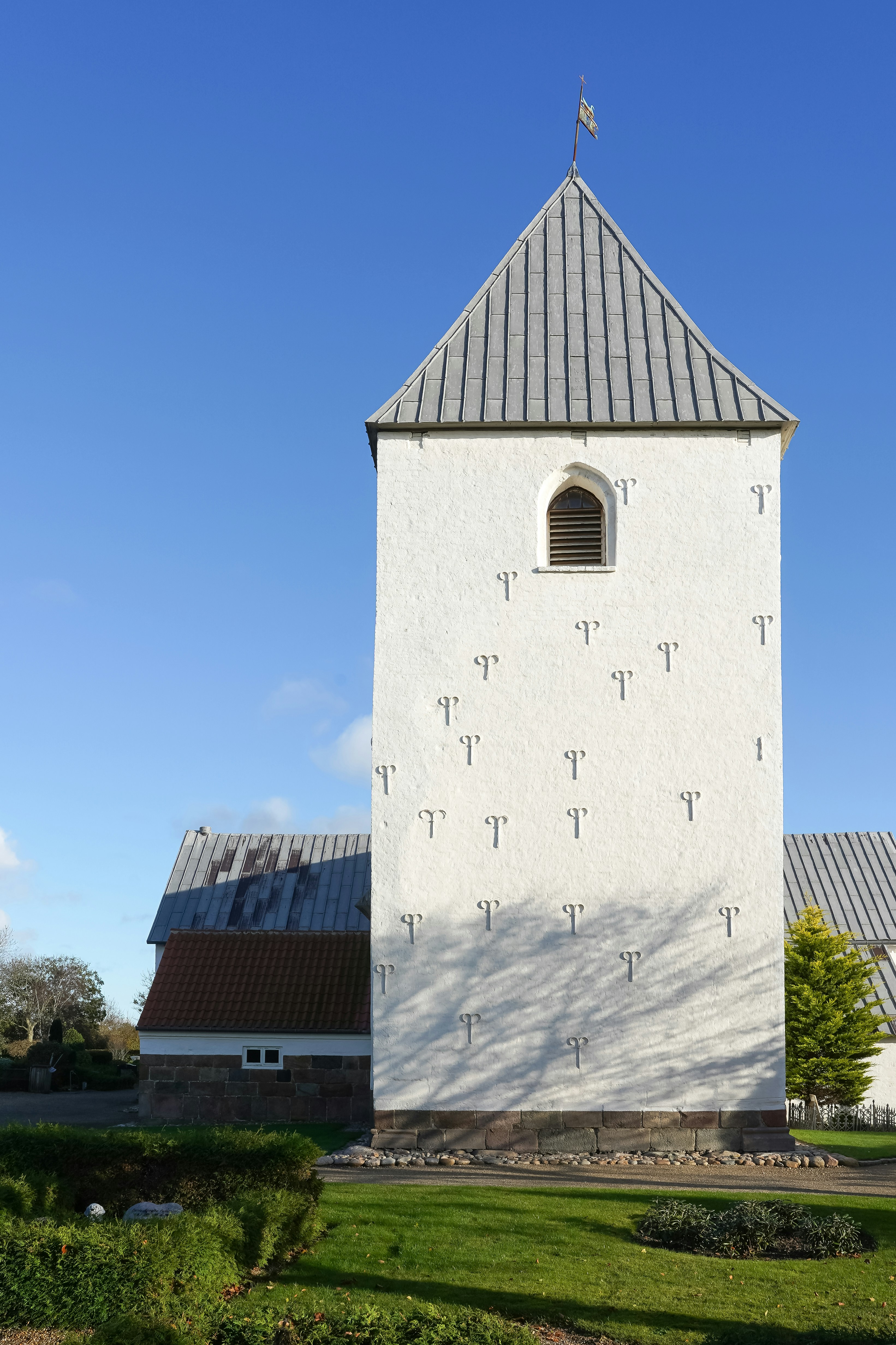 White Tower under a Clear Blue: A Quiet Chapel Rising Amid Green Grounds