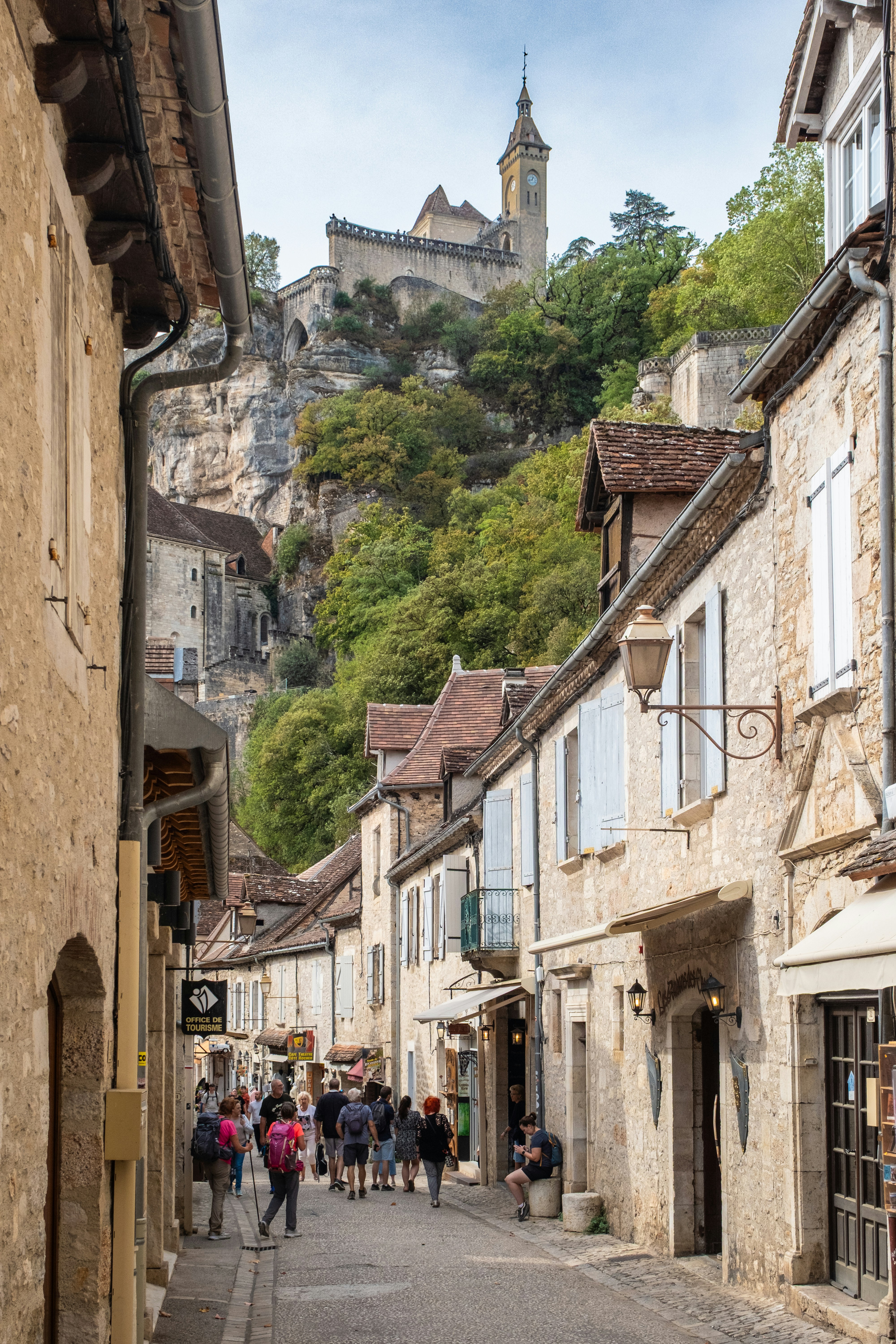 Ancient village street leading to hilltop church with castle atop cliffs