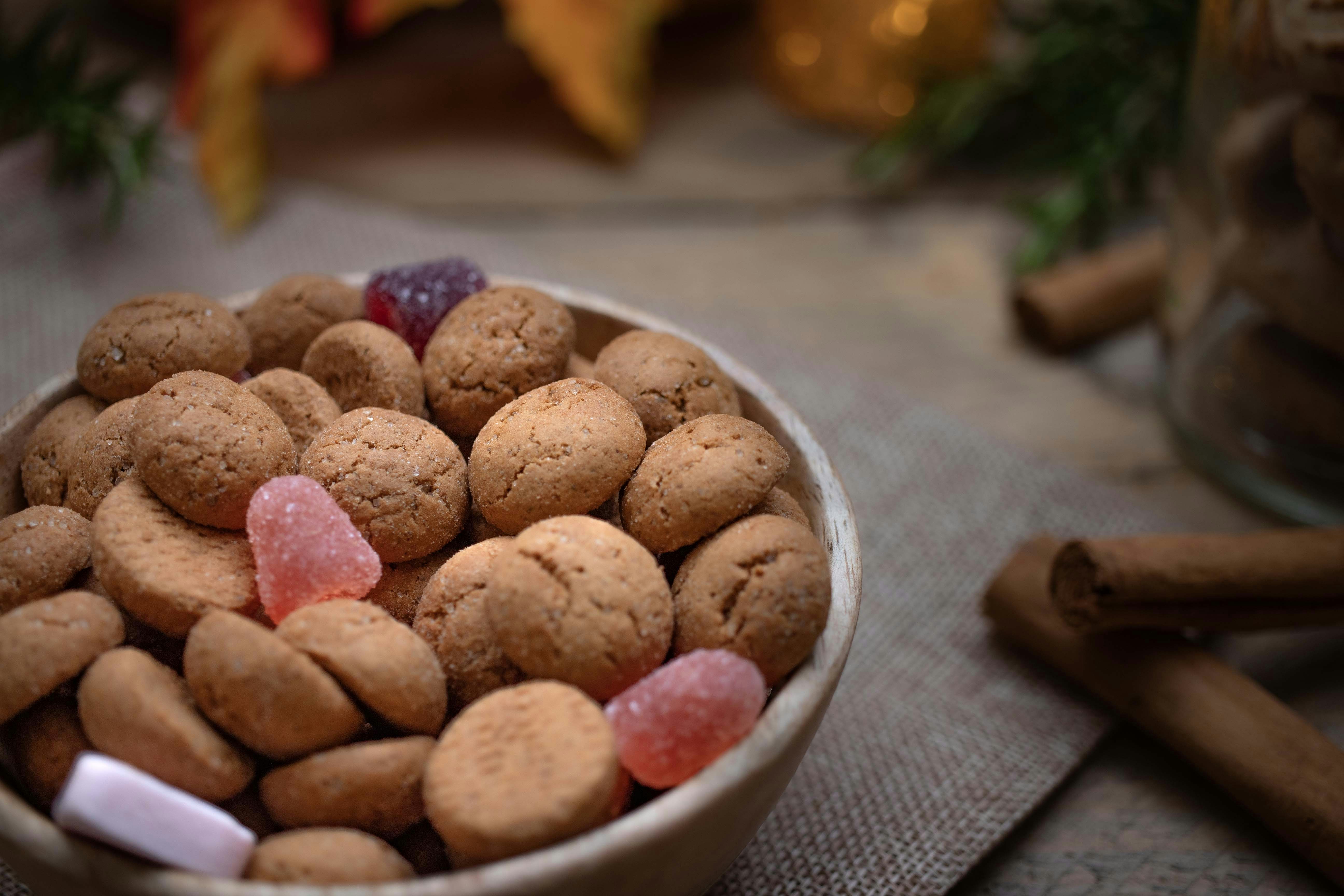 Sugar-coated Nibbles: A Bowl of Tiny Treats Amid Cinnamon Sticks