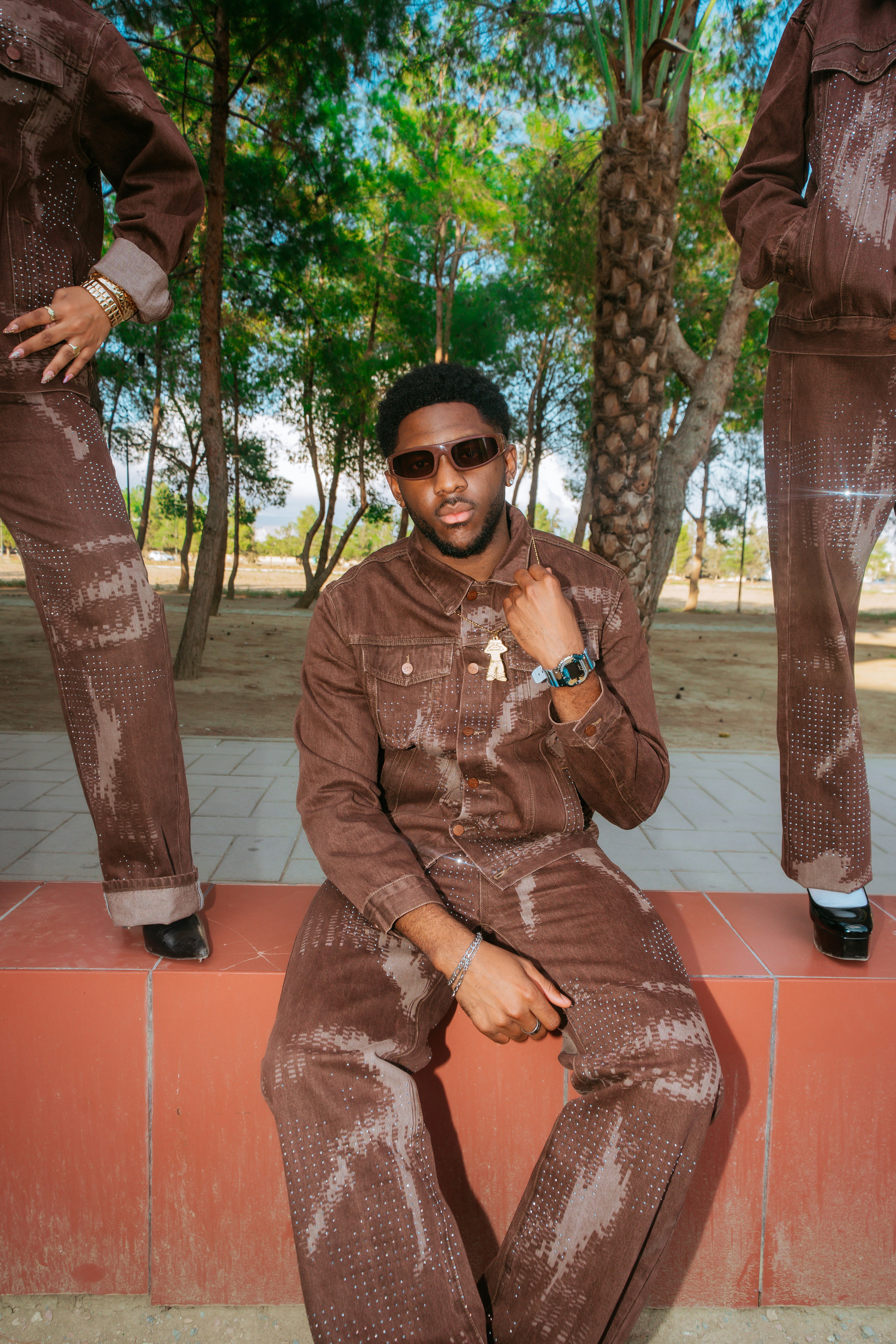 Centered in Style: A Trio in Sepia-Tone Streetwear Posed Under Palm Shade