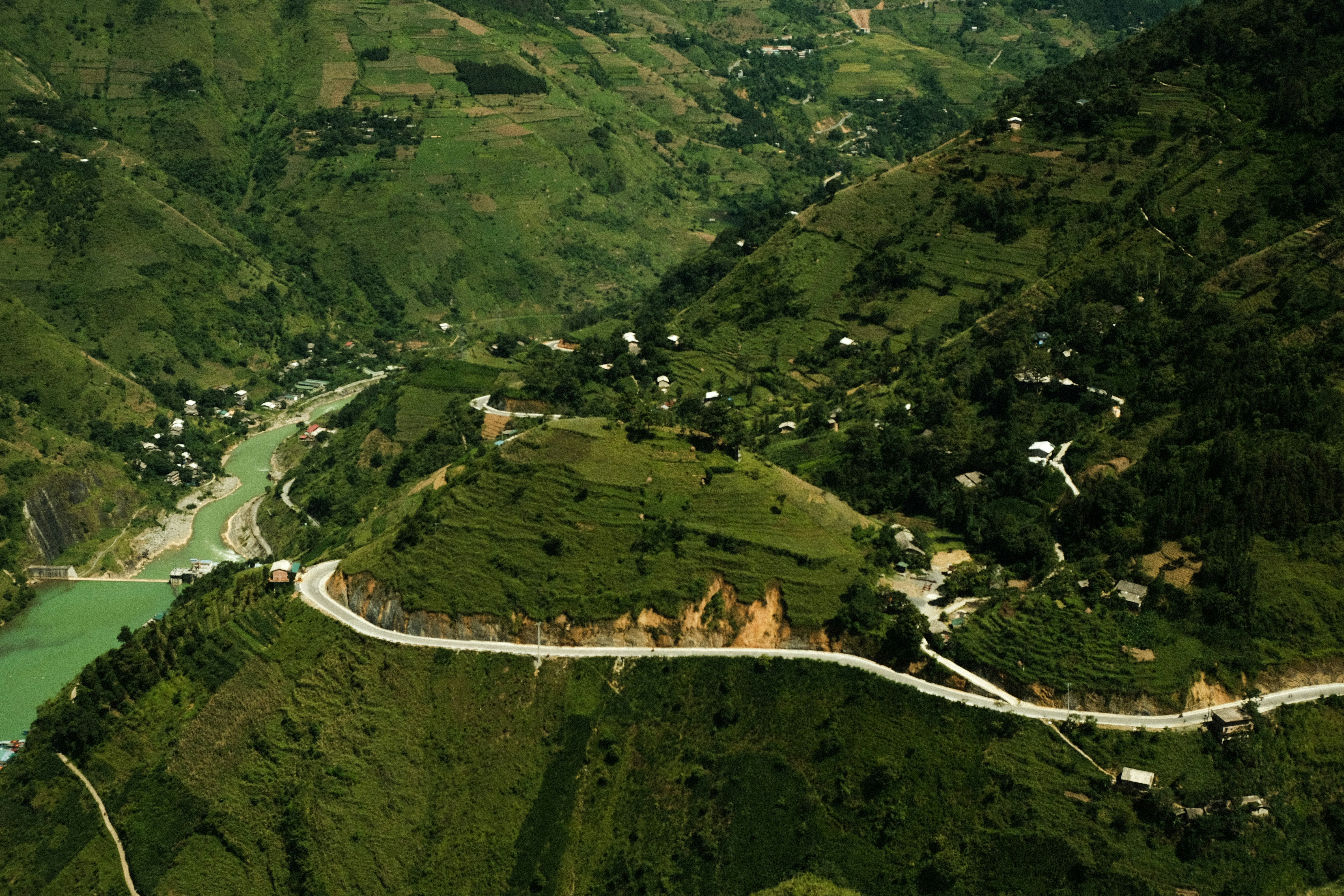 Serpentine Road Winding Through Terraced Green Valleys