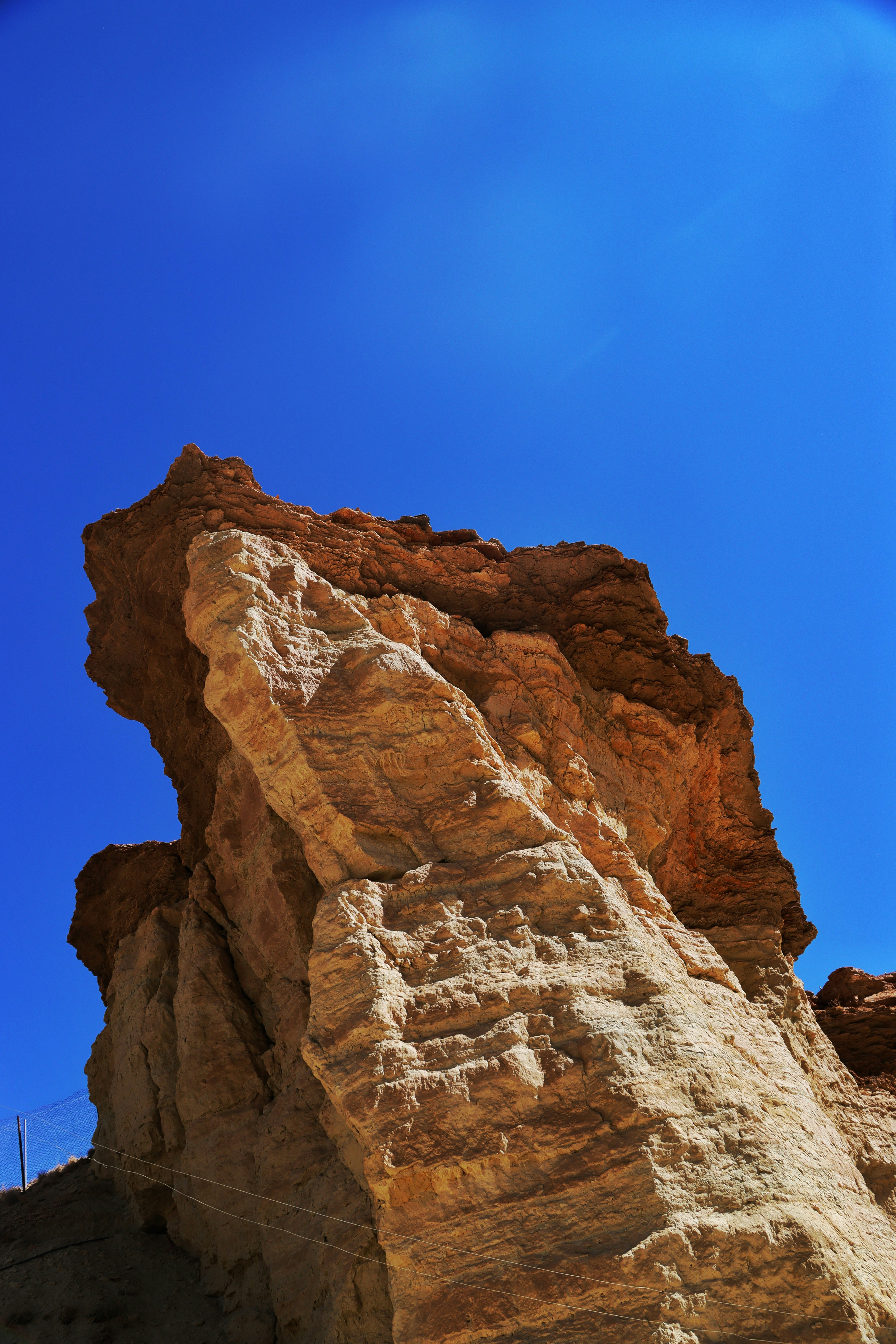 Verdant Sky and ancient cliff: sculpted sandstone against a cobalt dome