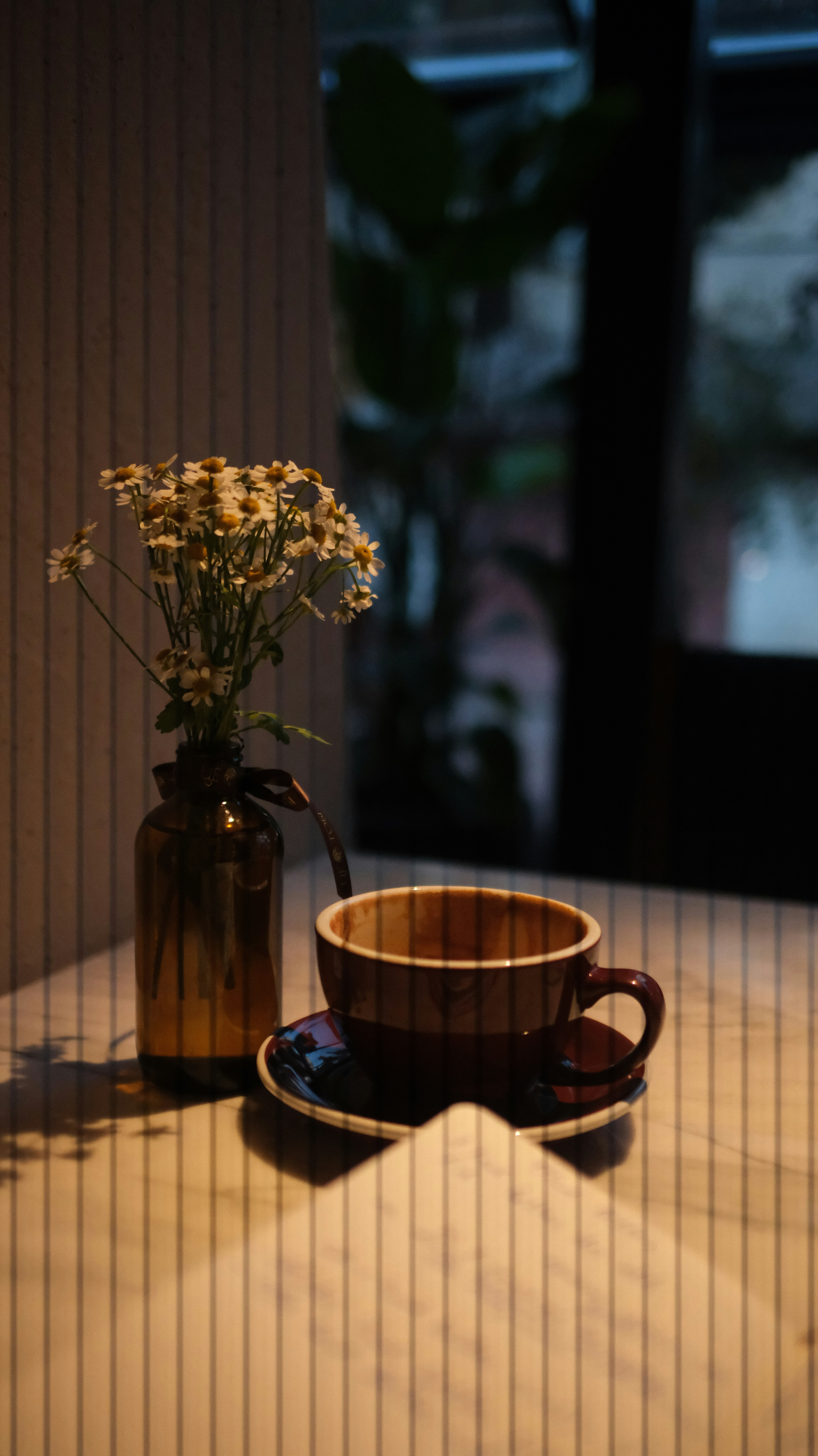 Tea Light and Daisies: Quiet Afternoon in a Dim Café