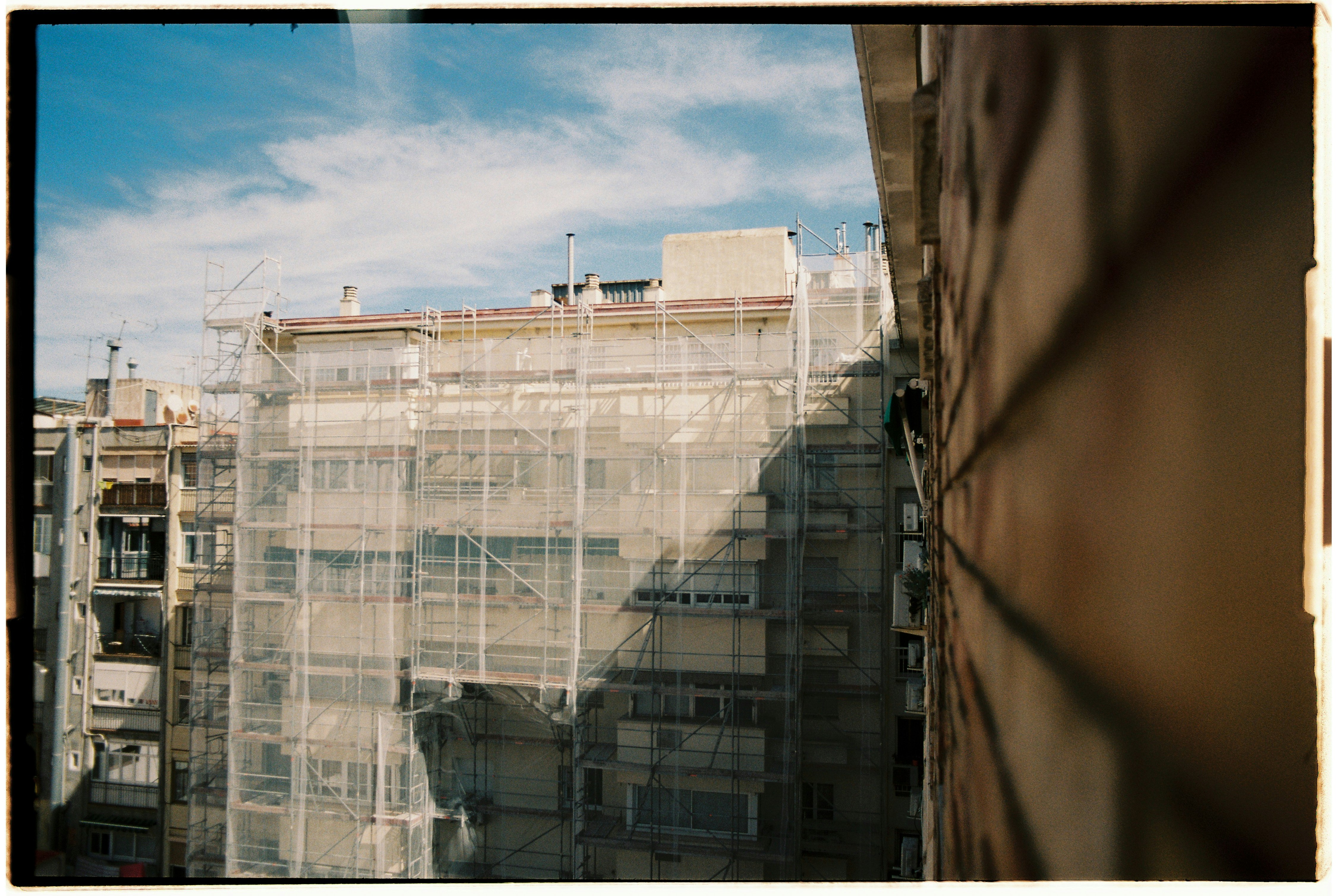 Urban scaffolded facade under a blue sky