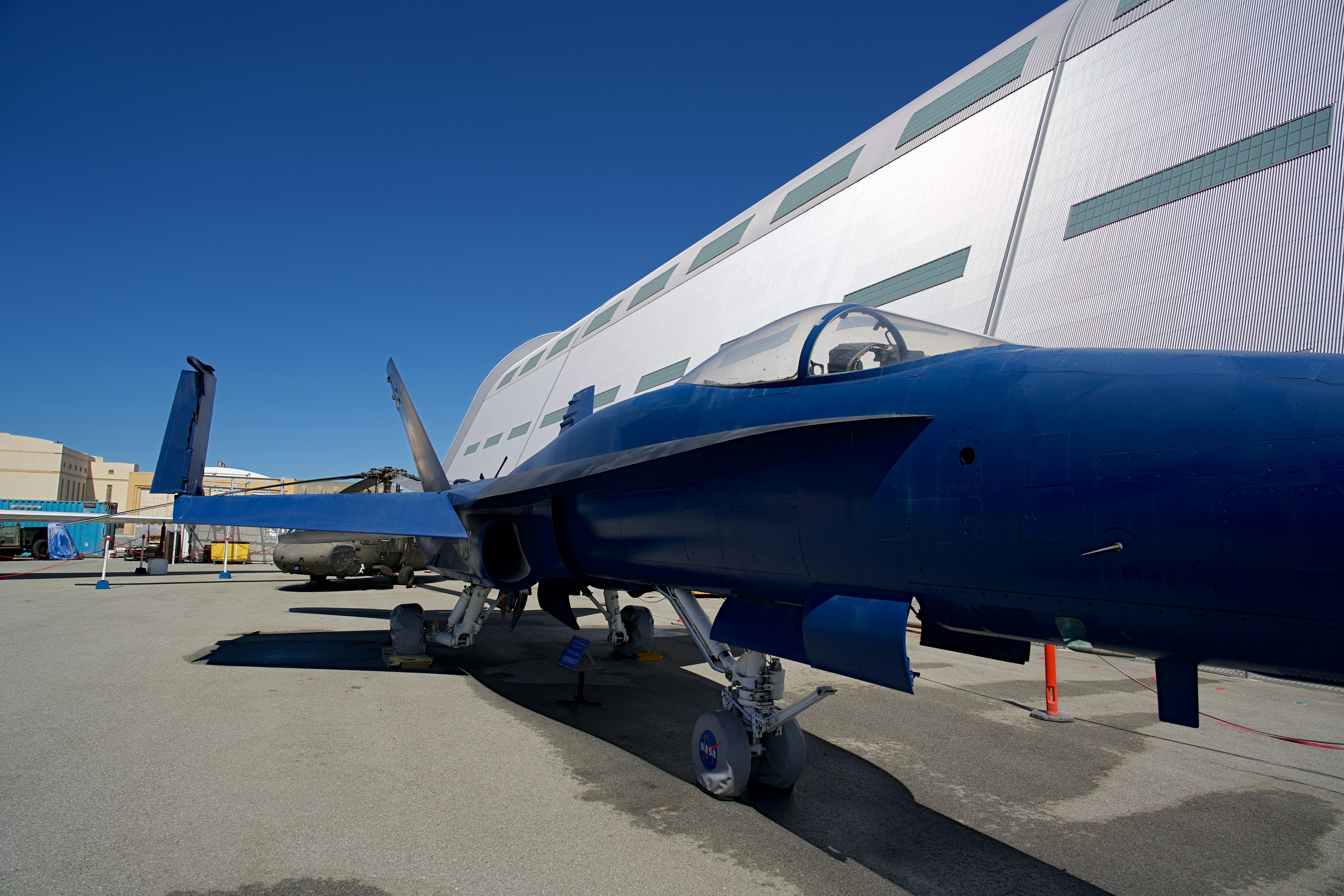 Blue jet at the edge of a sunlit tarmac, ready for flight