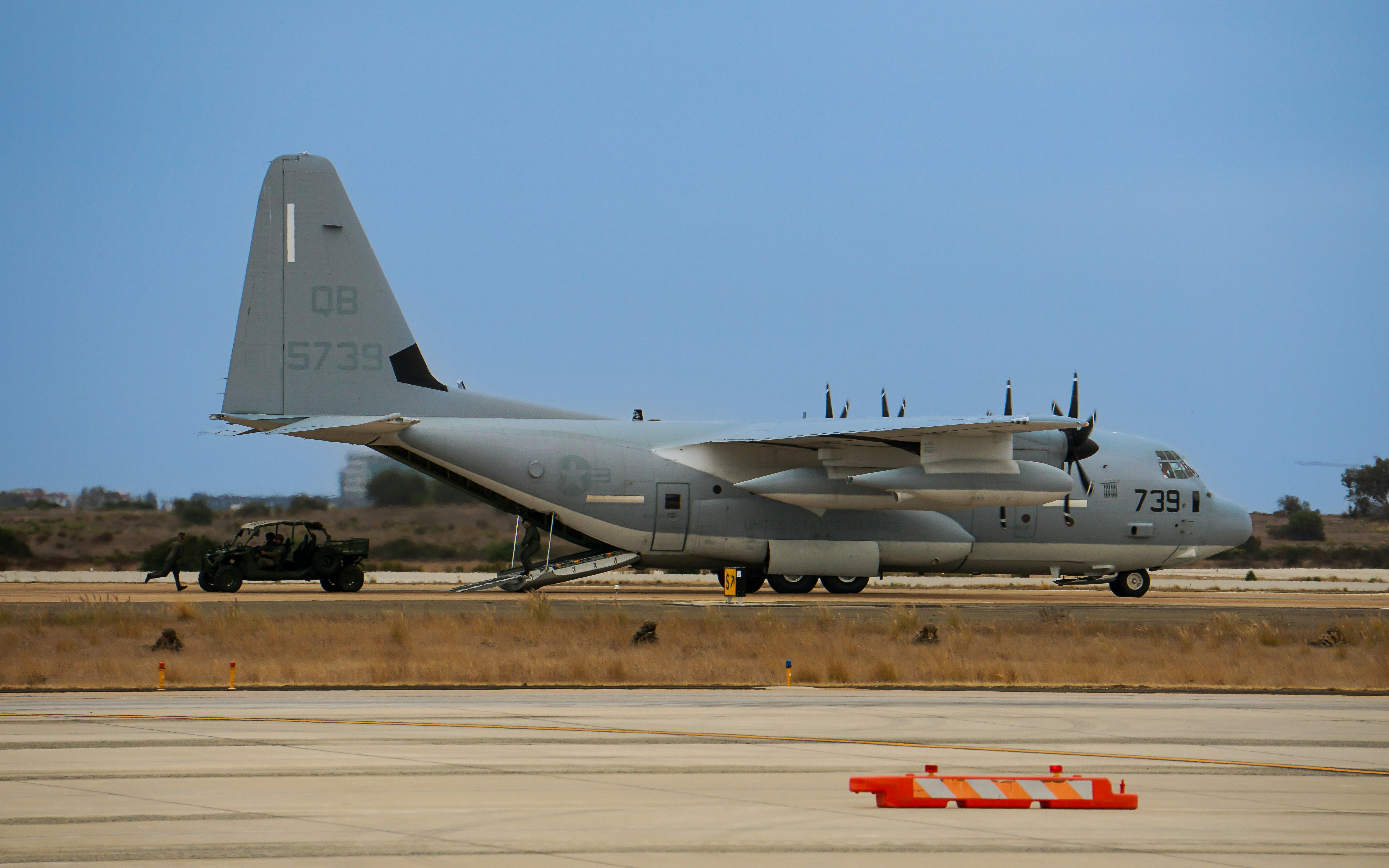 Marshaled Behemoth: A military transport sits ready on a sunlit tarmac