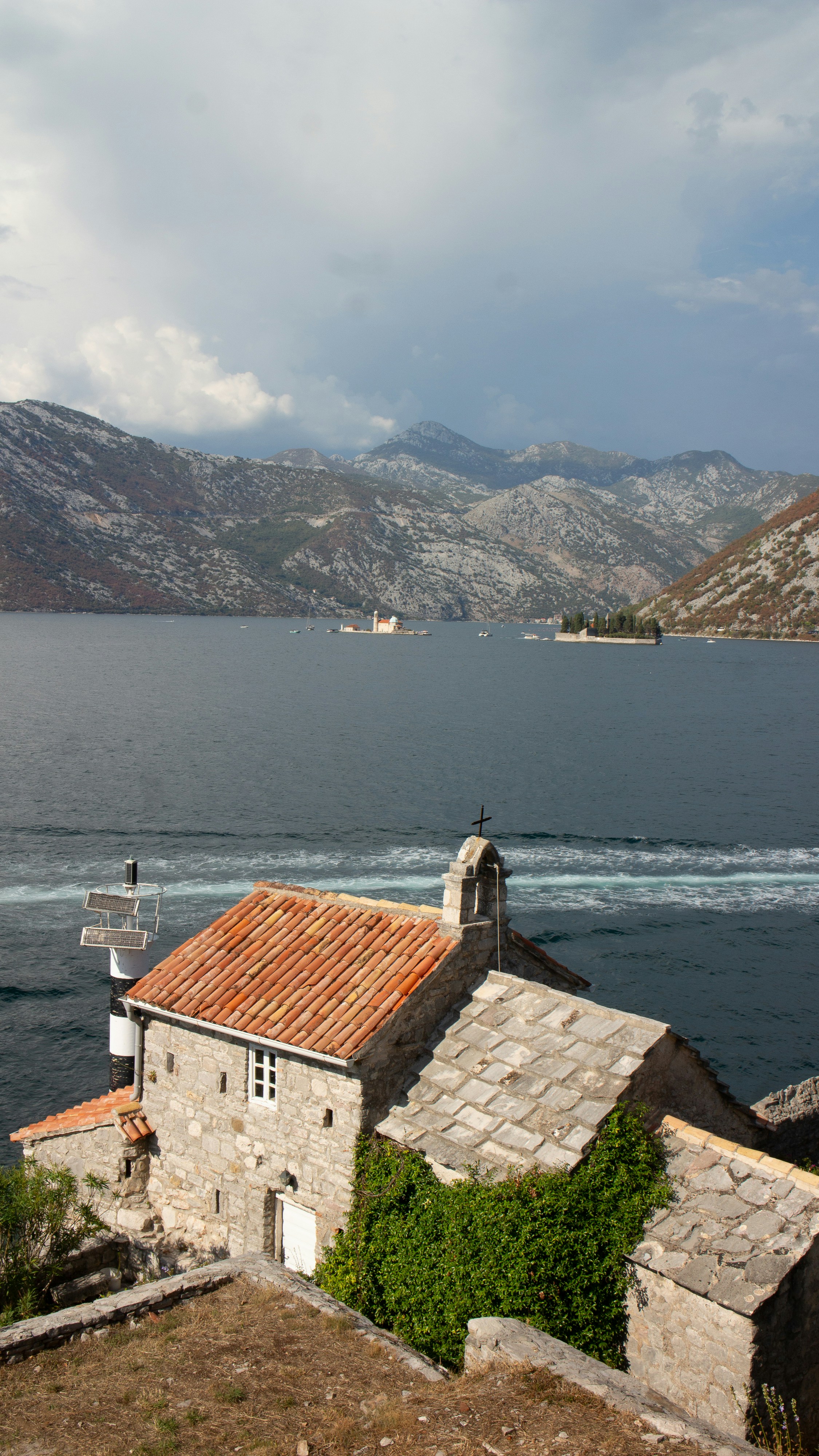Stone House on the Sea Cliff with Mountain Backdrop