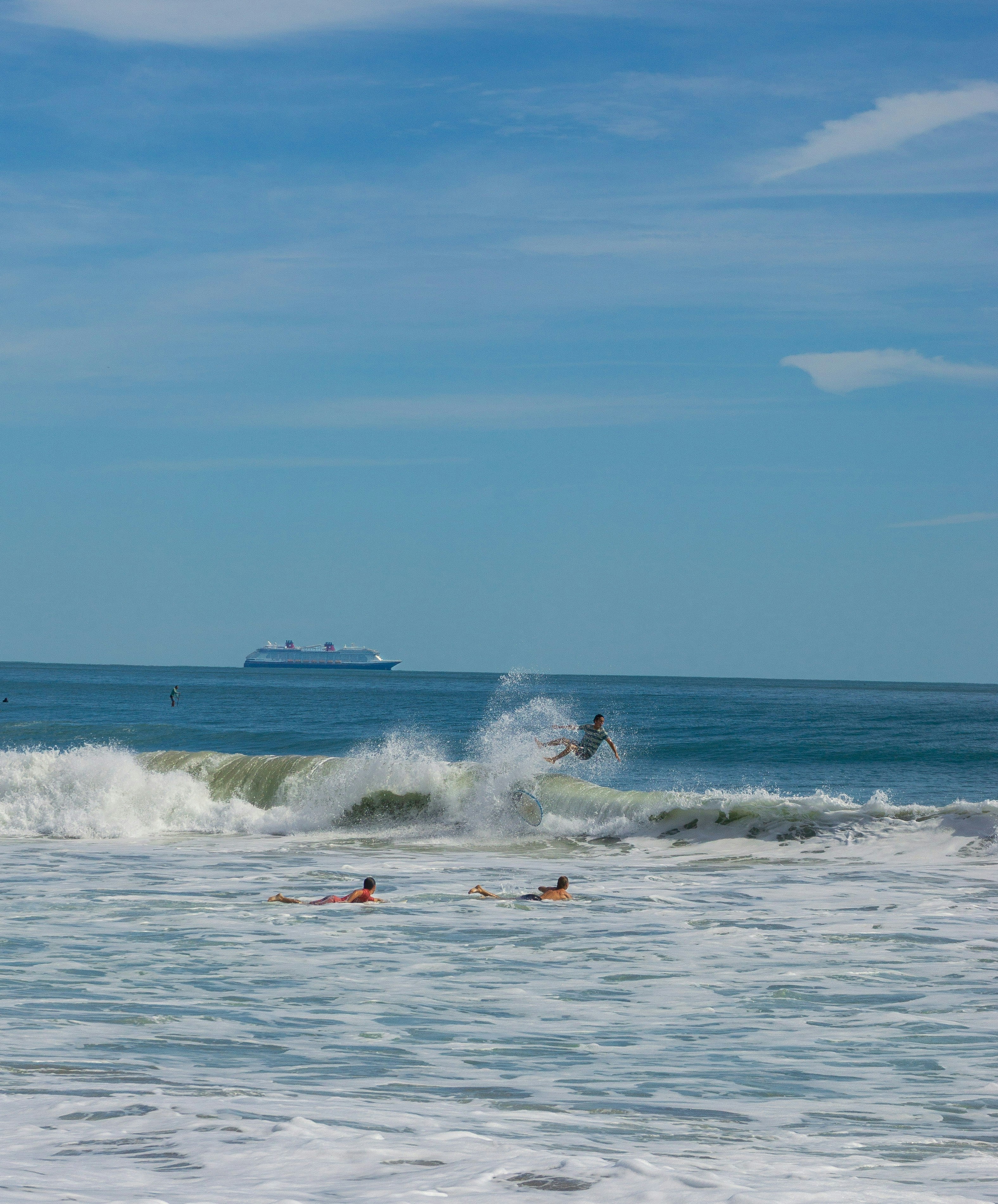 Surfer's Crest: A Wave, a Splash, and a Distant Ferry