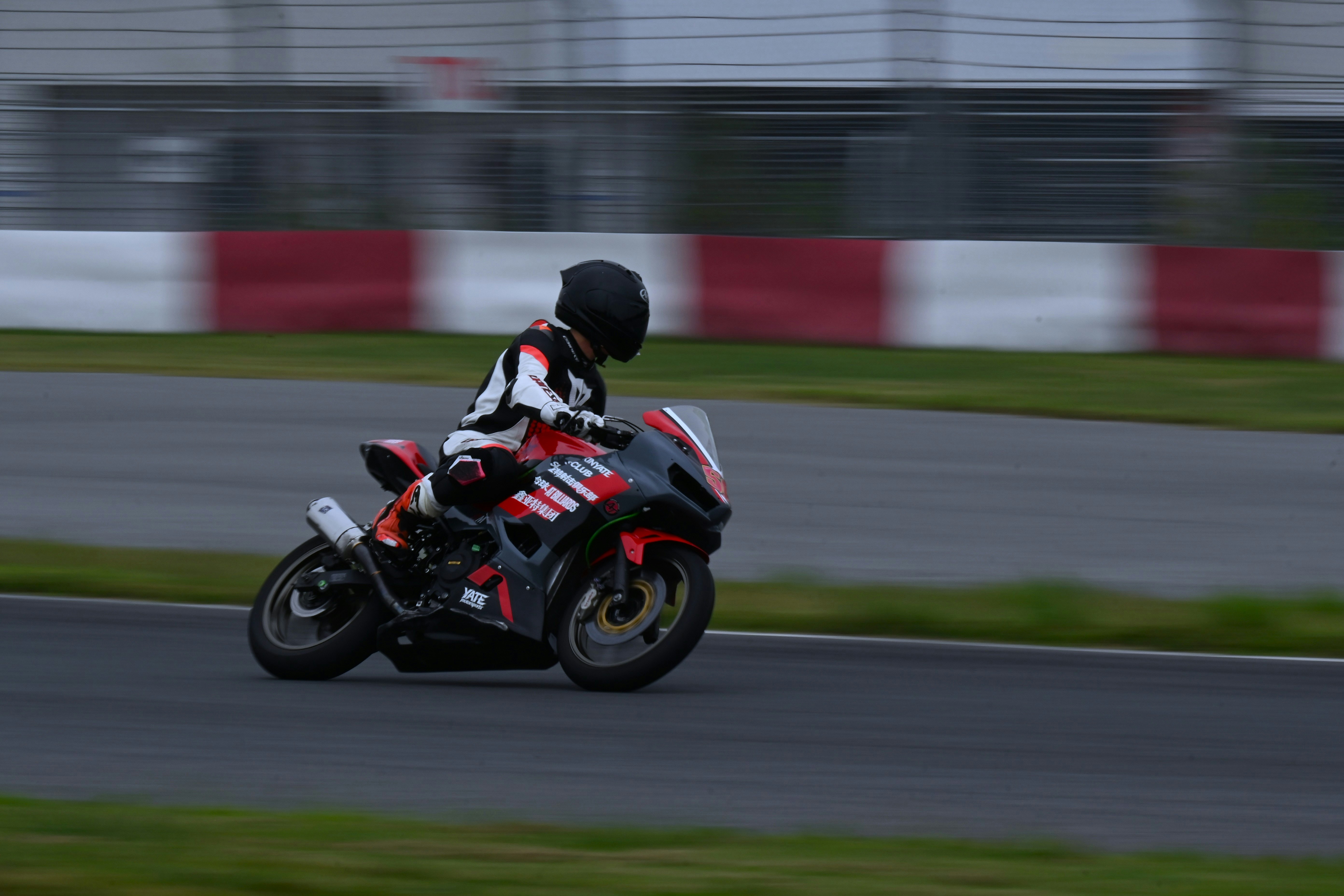 Speeding Shadow: A Rider Carves the Curve on a Red/Black Mini Bike