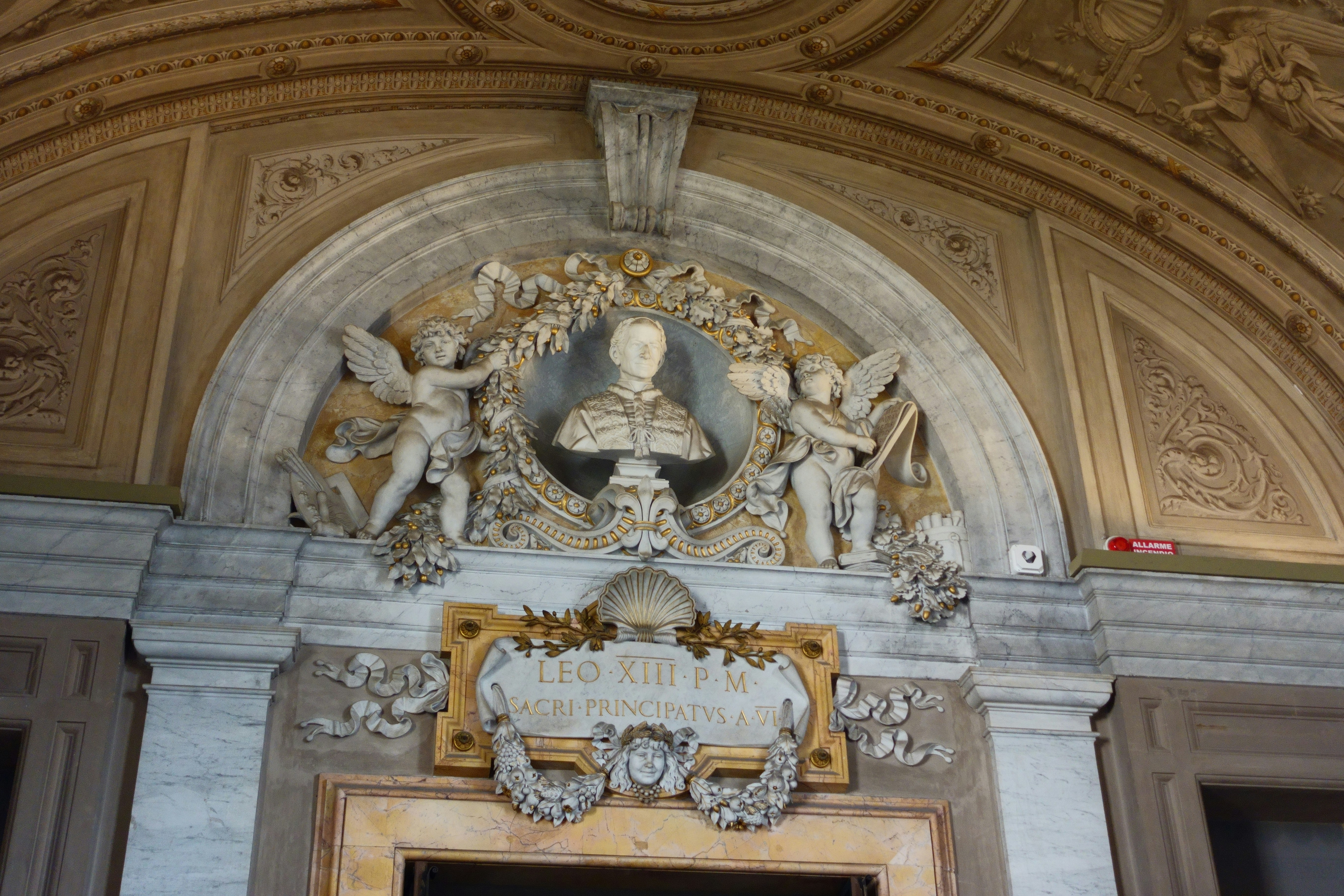 Marble bust of Pope Leo XIII flanked by two cherubs in a vaulted alcove