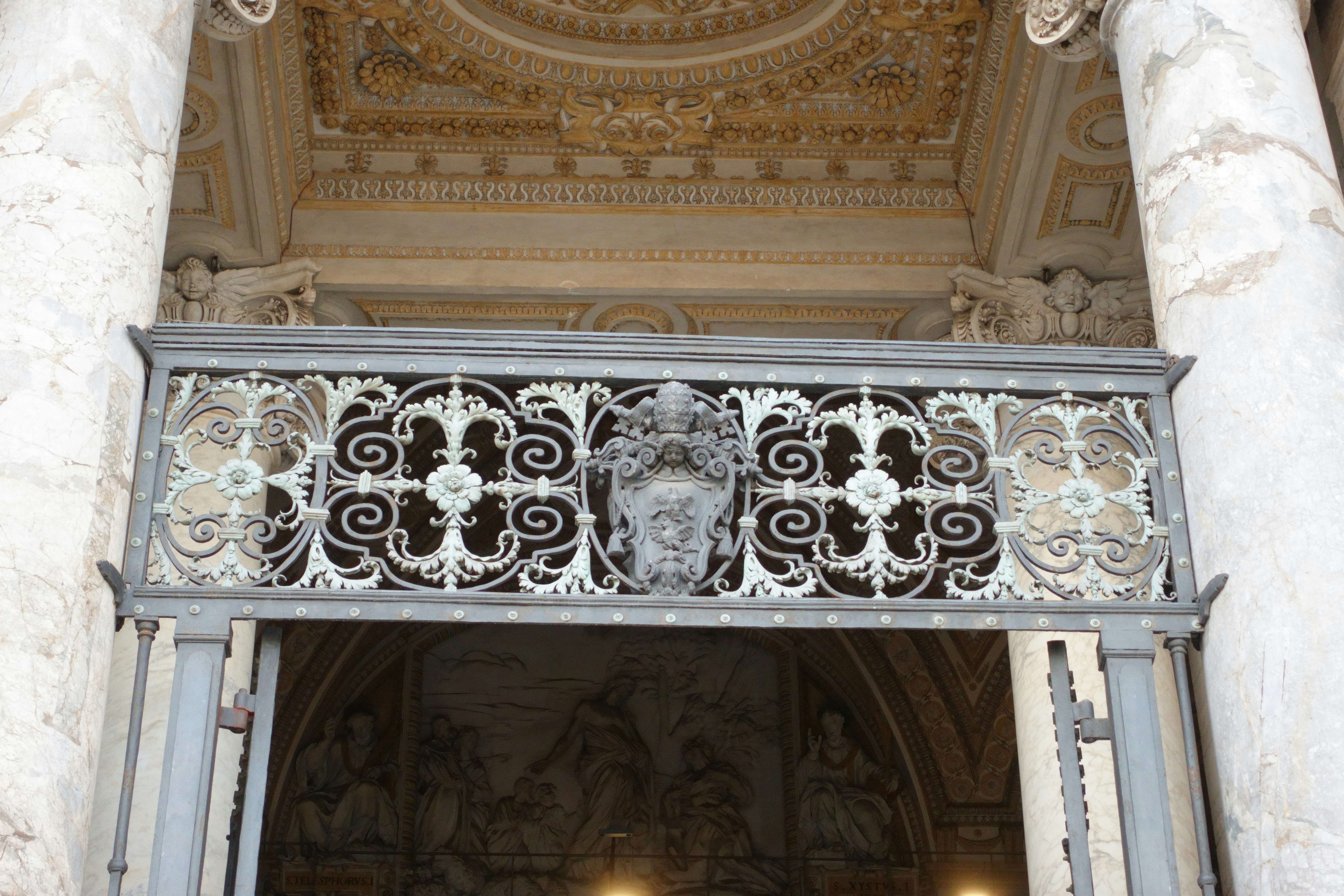 Ornate Ironwork Gate Framing a Sculpted Archway