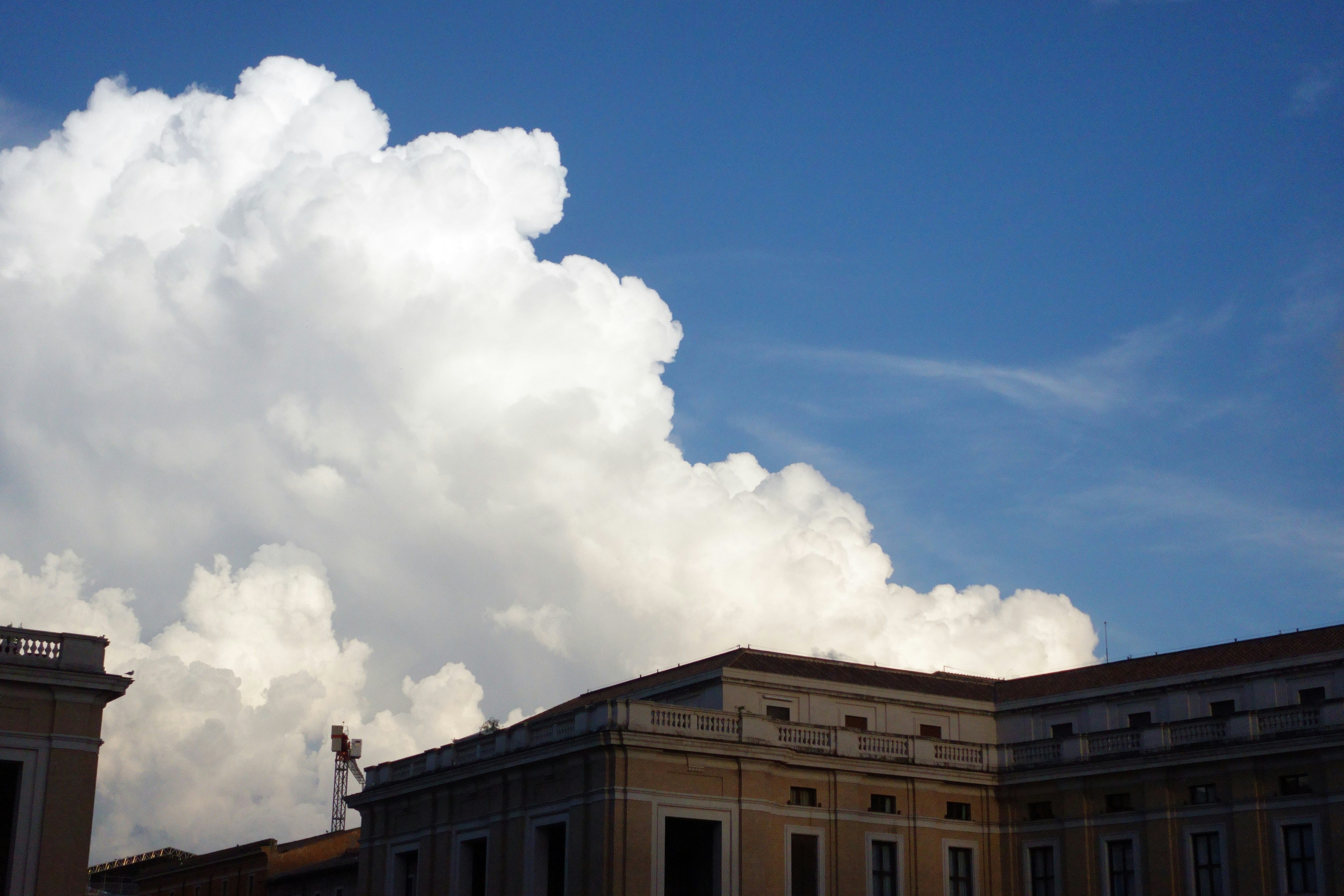 Skyward Edge: Cloud Crown Above Classical Facades