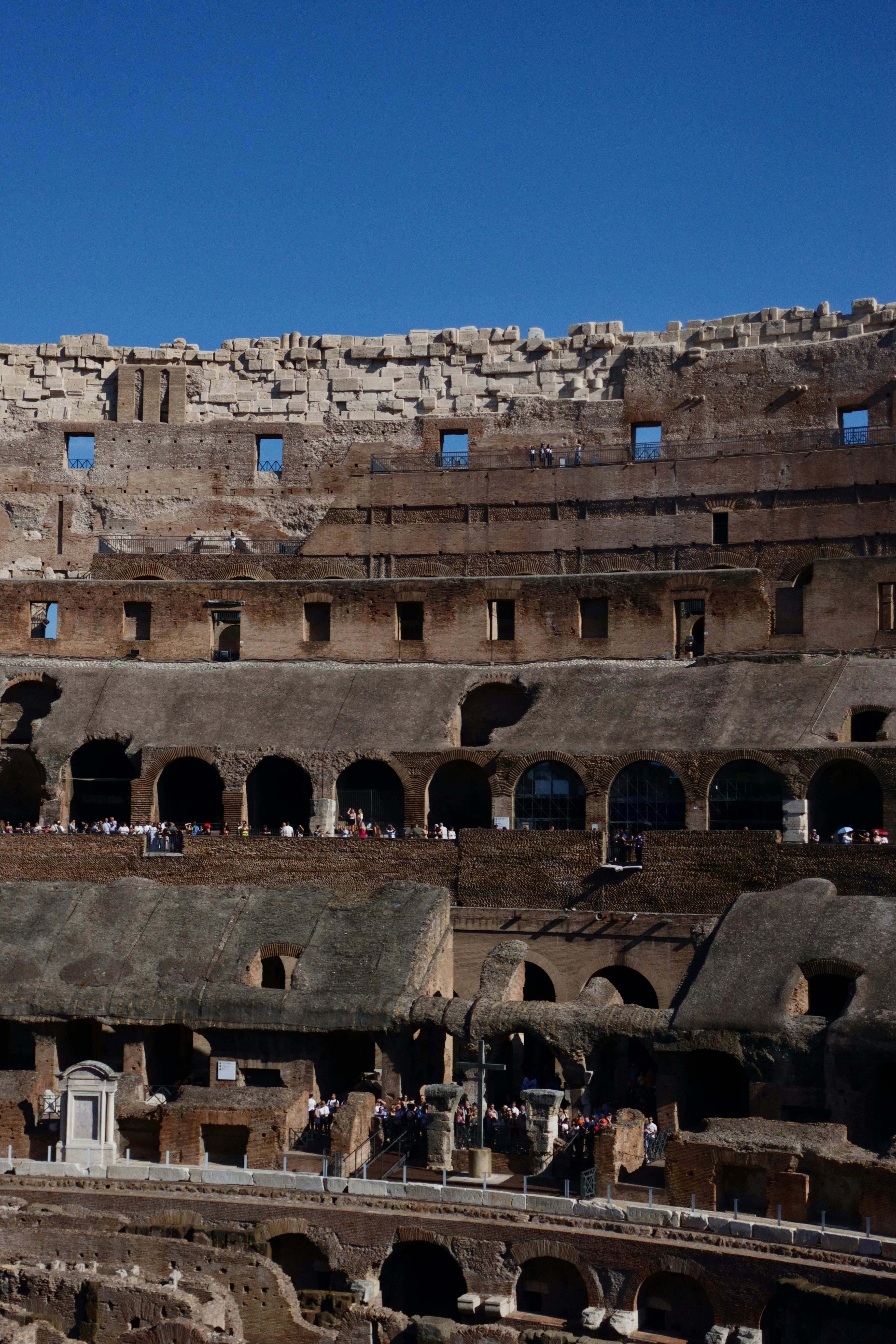 Whispers of the Arena: Sunlit Arches Beneath a Clear Sky