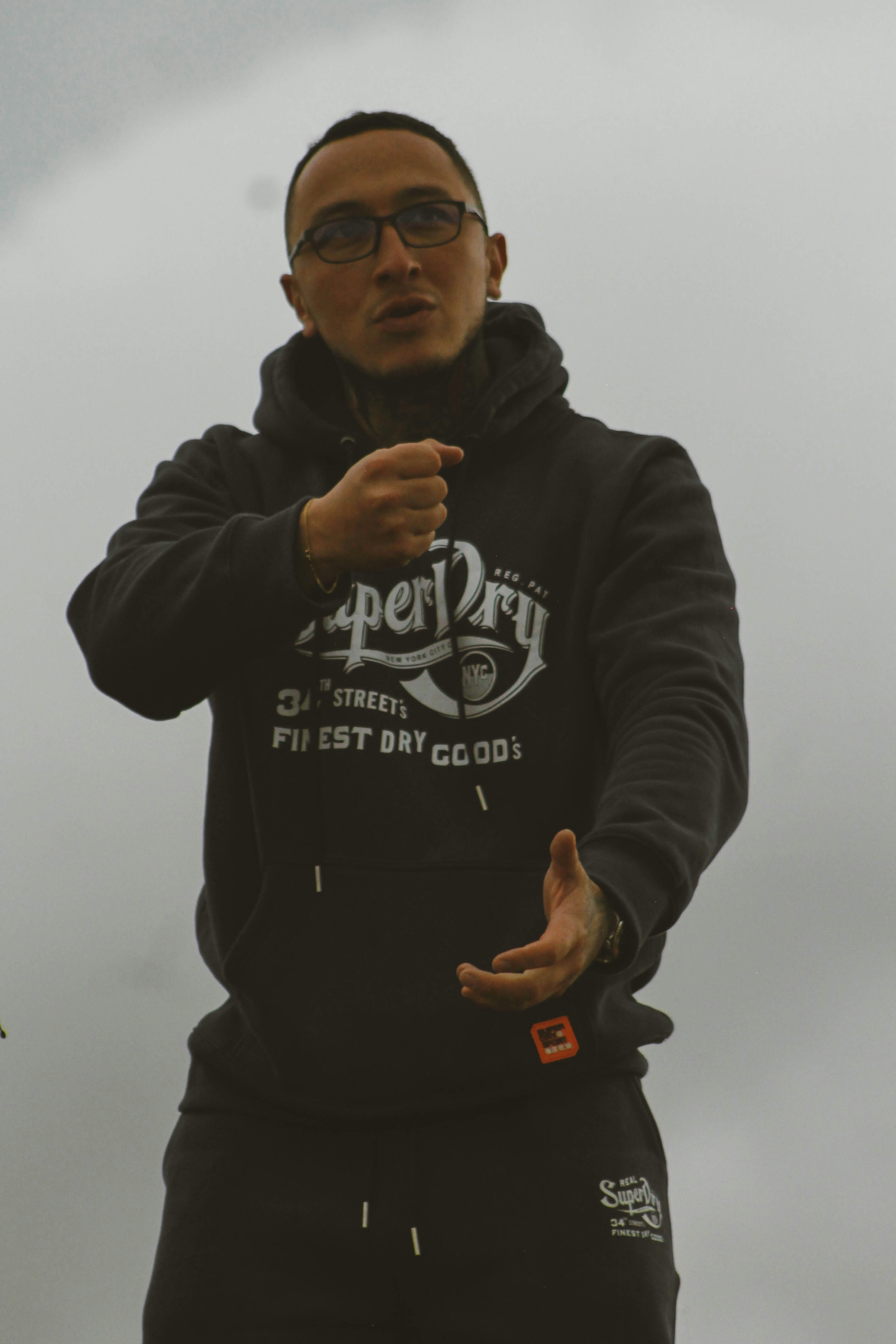 Hands in Motion: A Streetwear Pose Against a cloudy Sky