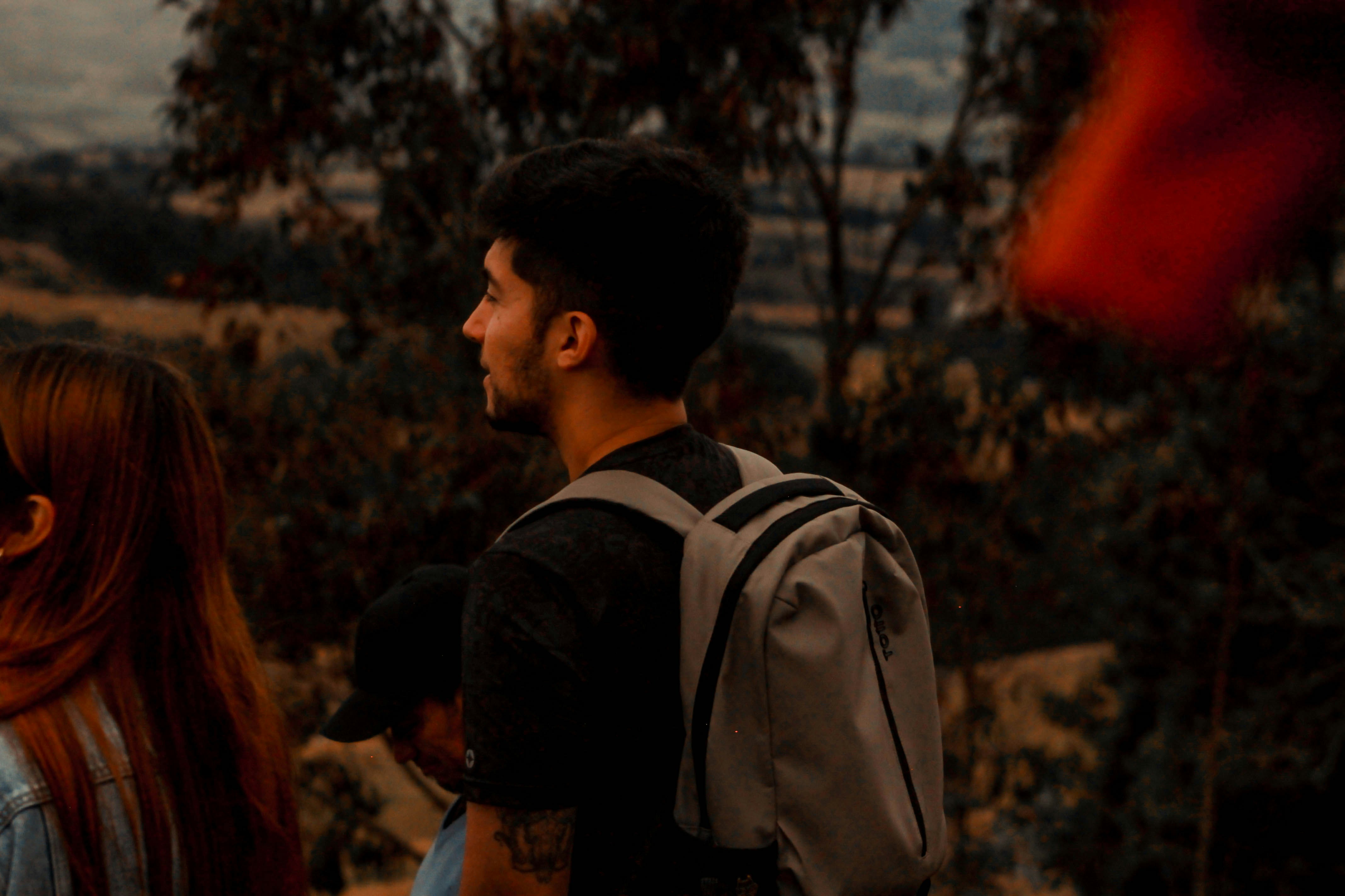 Backlit Traveler: A Quiet Moment with a Backpack in a Hazy Horizon