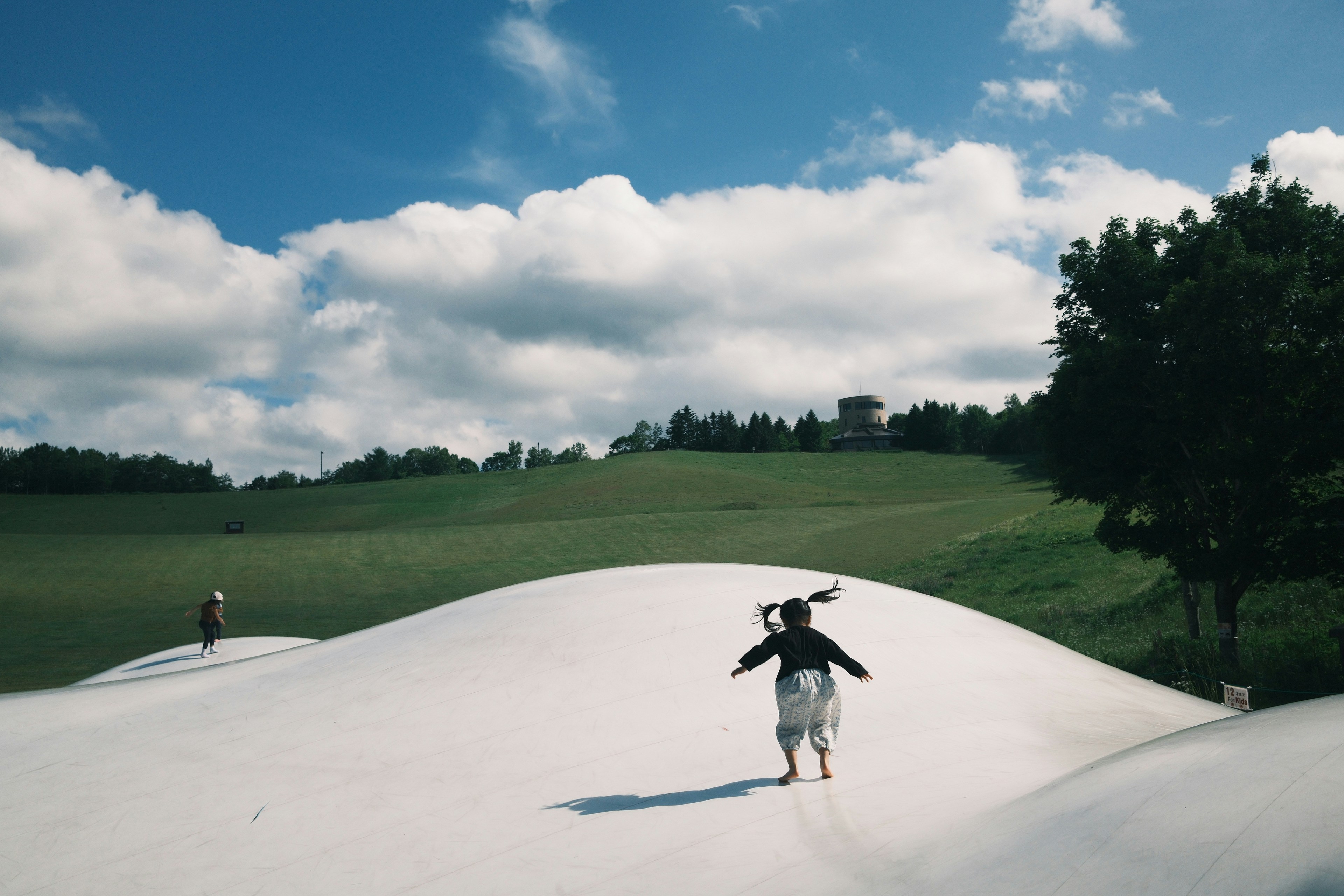 Joyful outline: child on a white hill under a blue sky