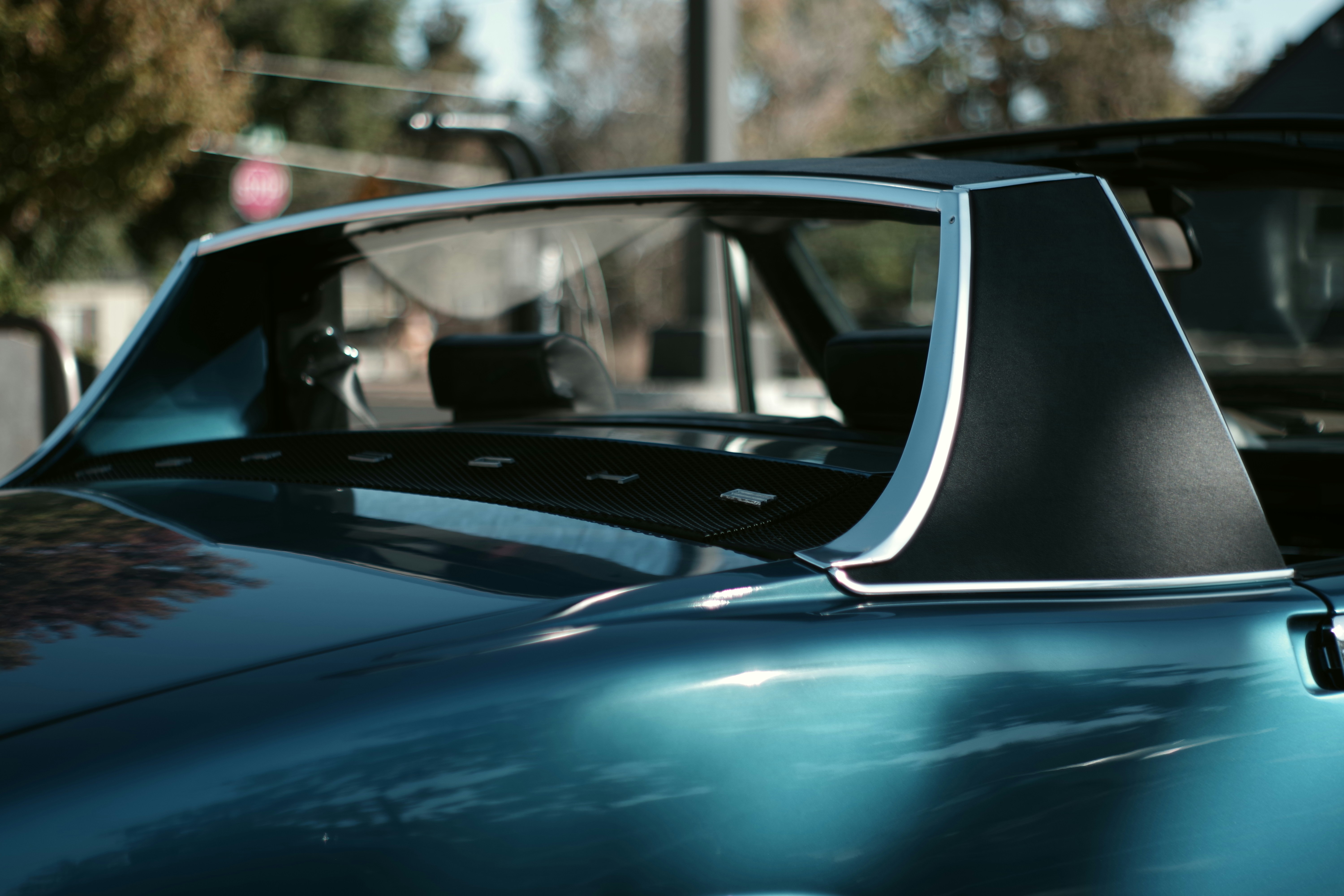 Shiny teal neck of a classic car with a retro spoiler silhouette