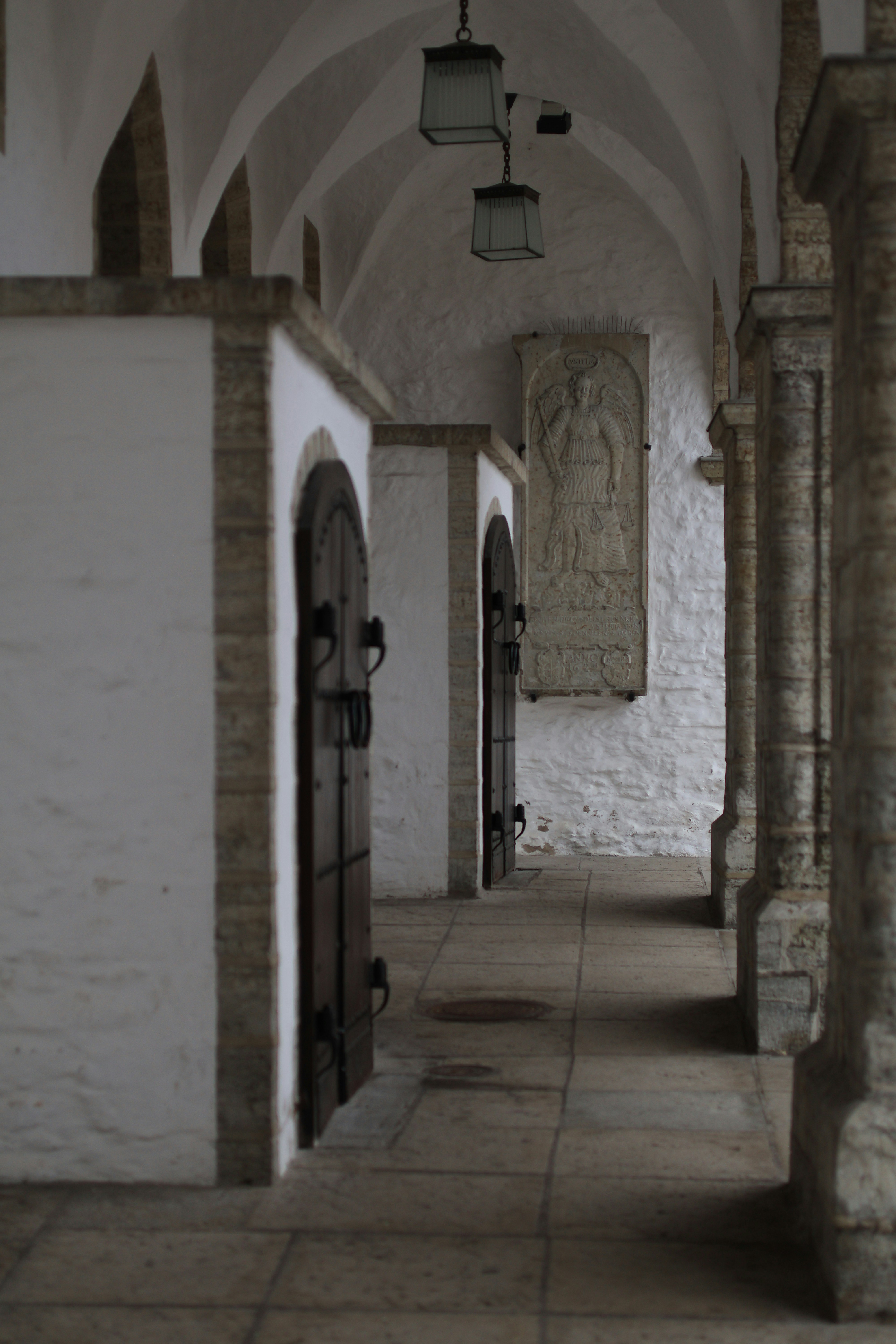 Stone Corridor with Hanging Lanterns and Sacred Relief