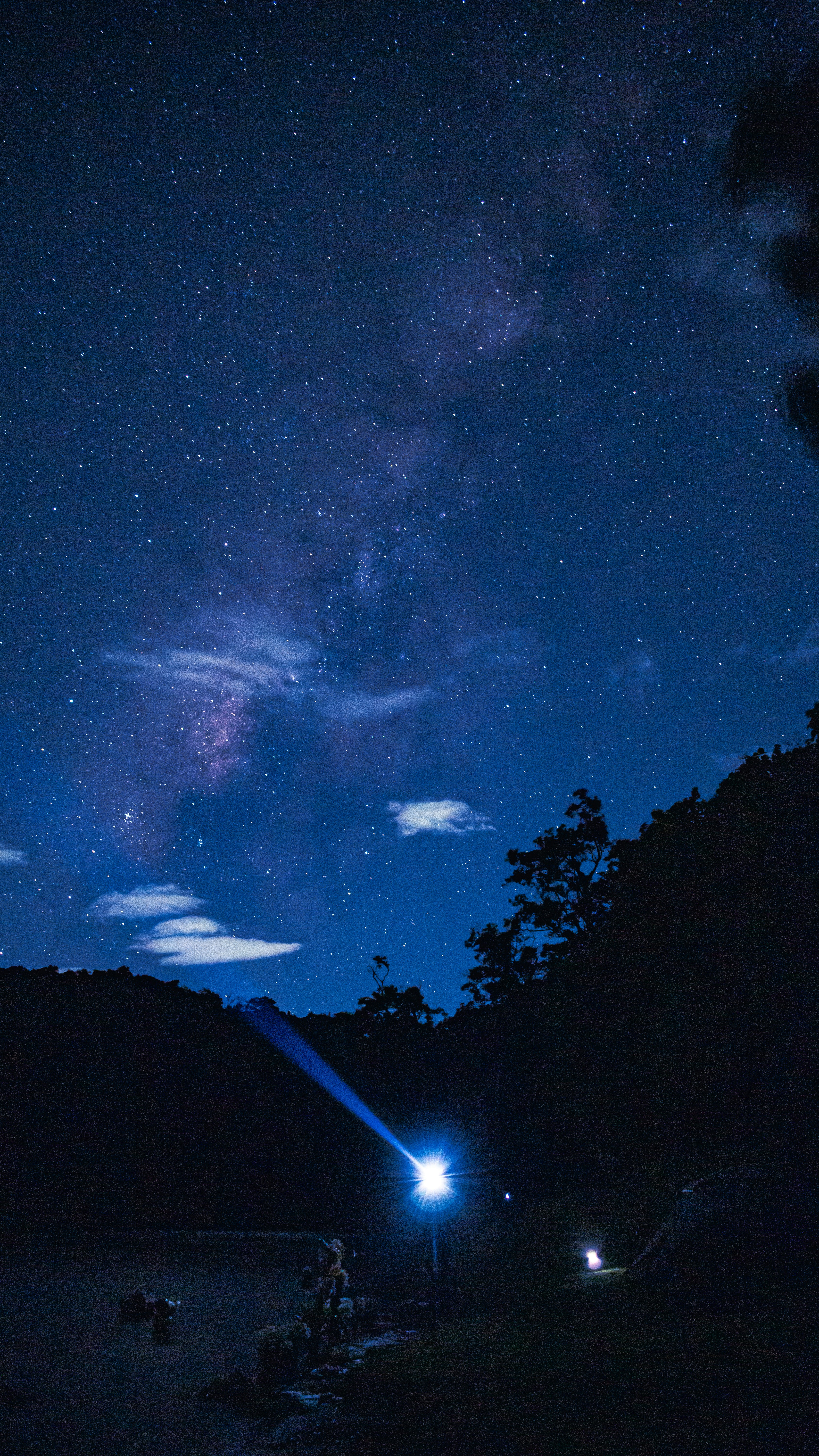 Night Sky Beacon Over the Silhouetted Hills