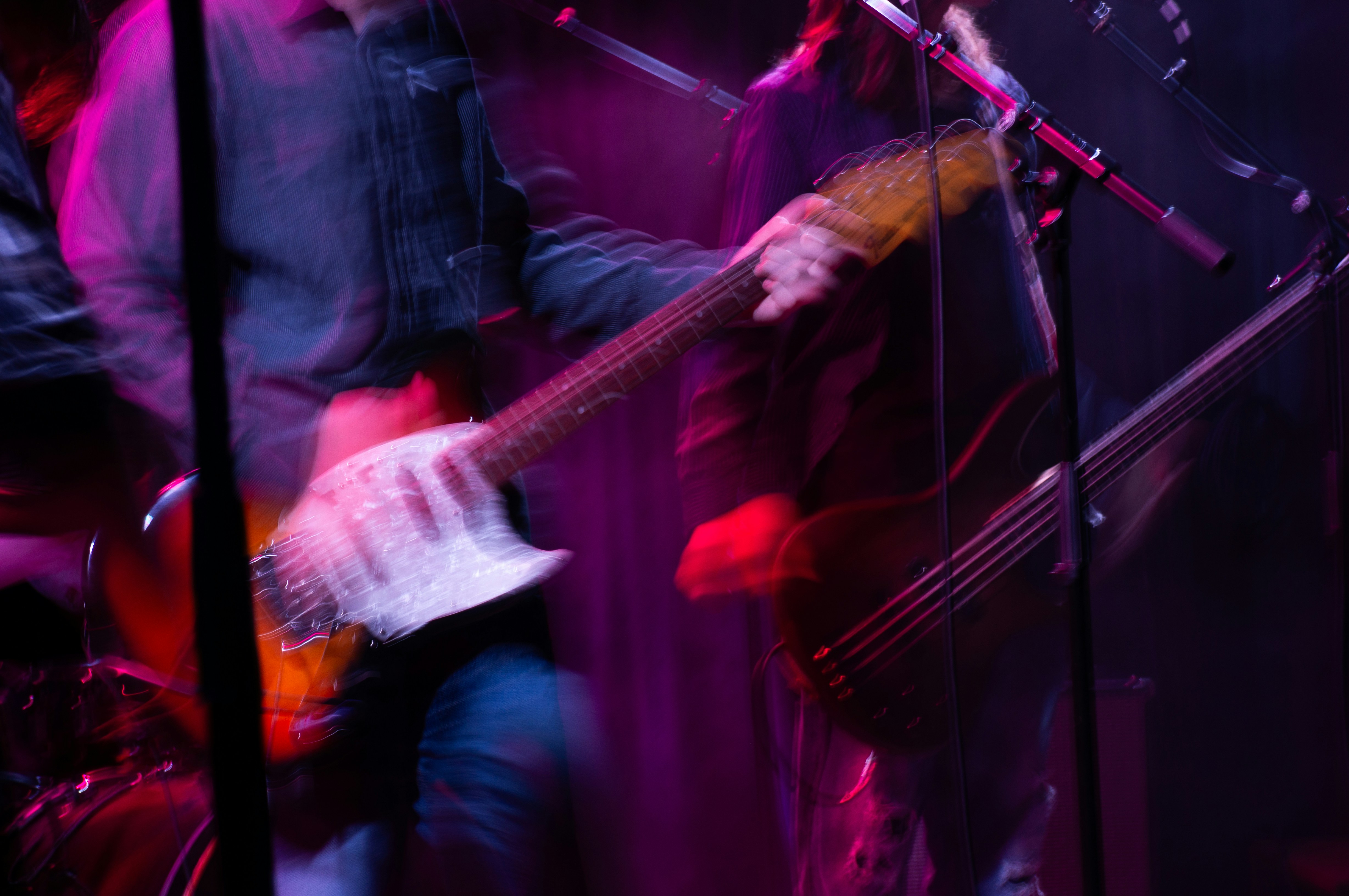 Motion in Neon Blues: A Blurred Guitar Scene at a Live Show