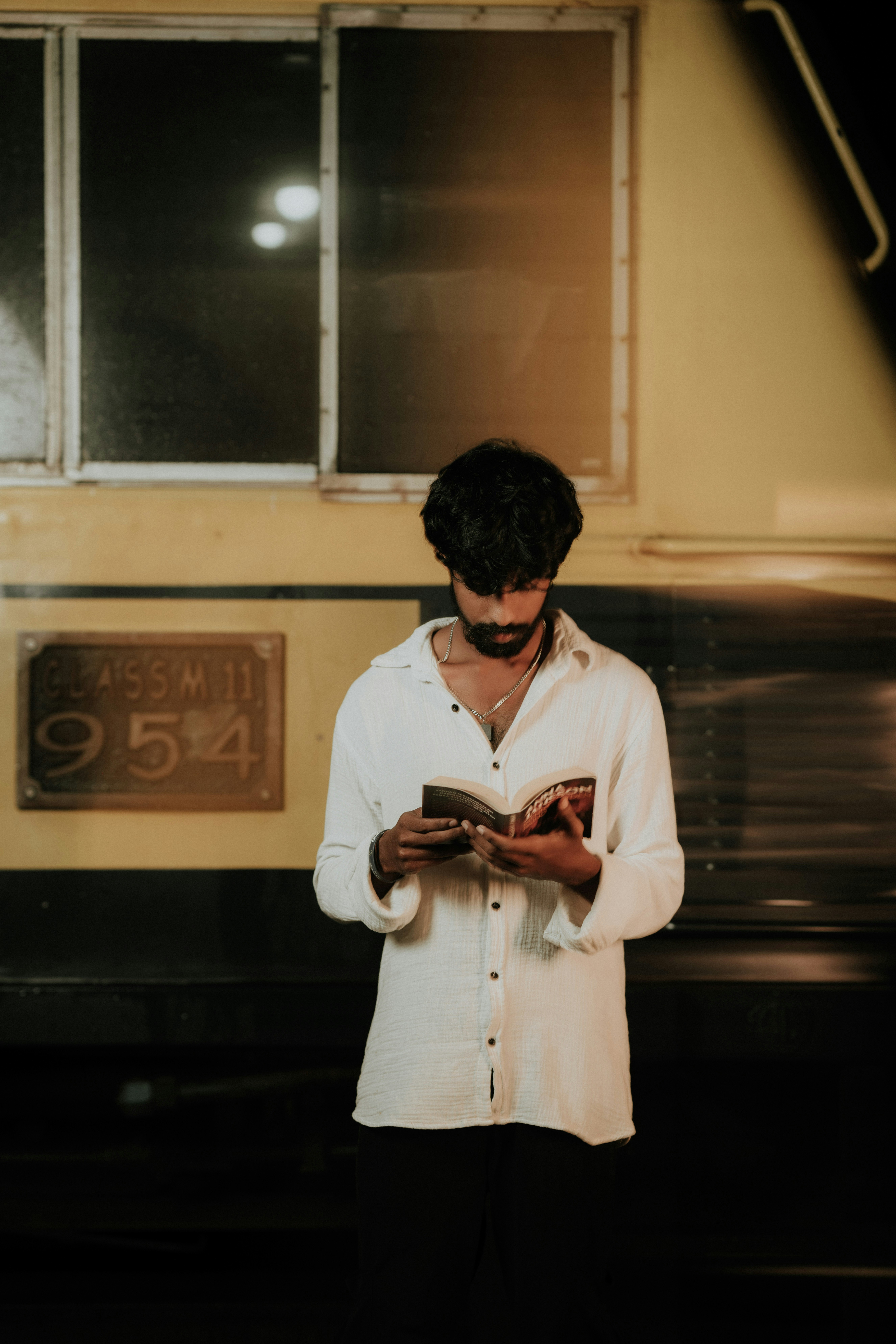 Reading in the Night Train: A Quiet Moment on a Dim Platform