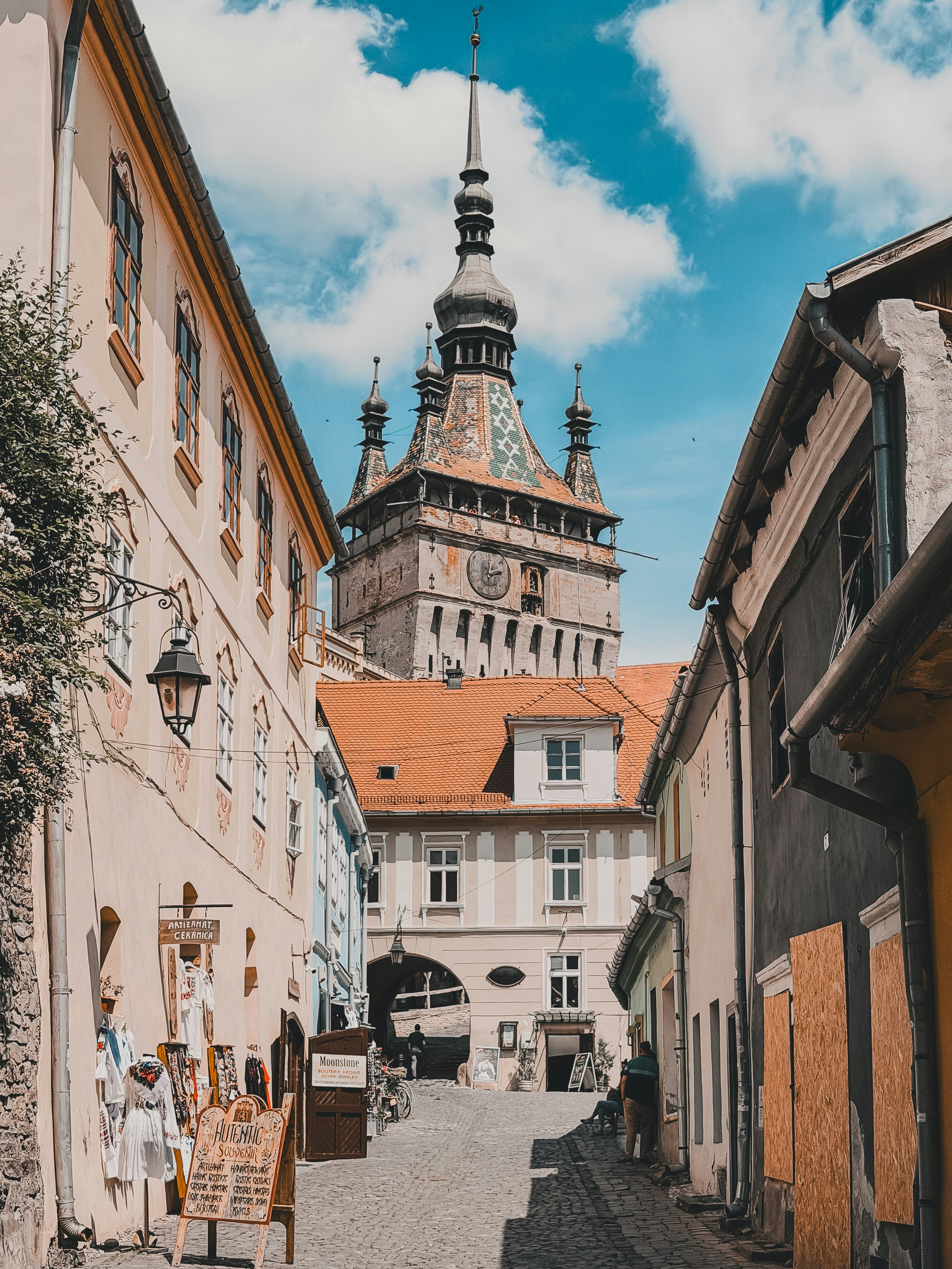Clock Tower Gate: A Sunlit Street to a Towering Spire