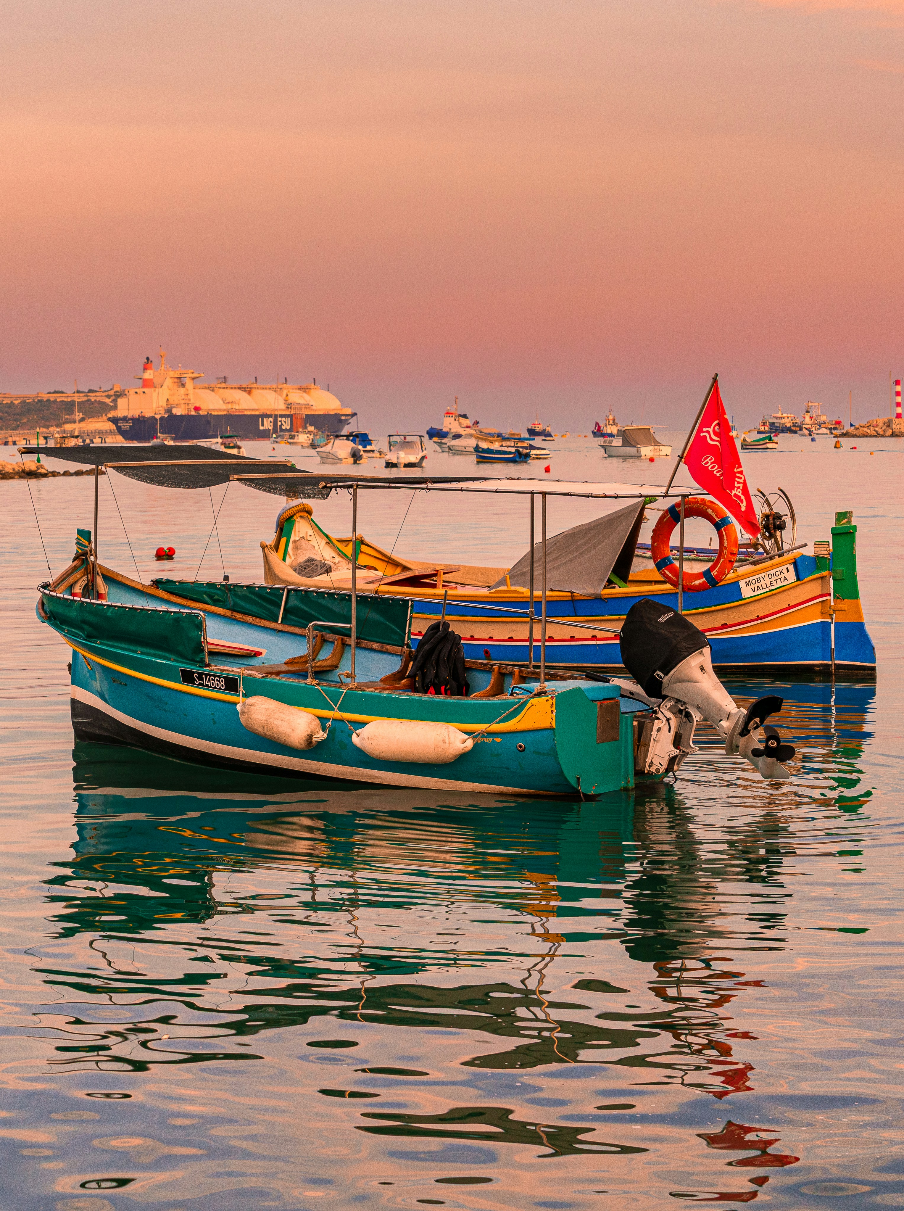Sunlit Cradle: Colorful Boats at Quiet Harbor