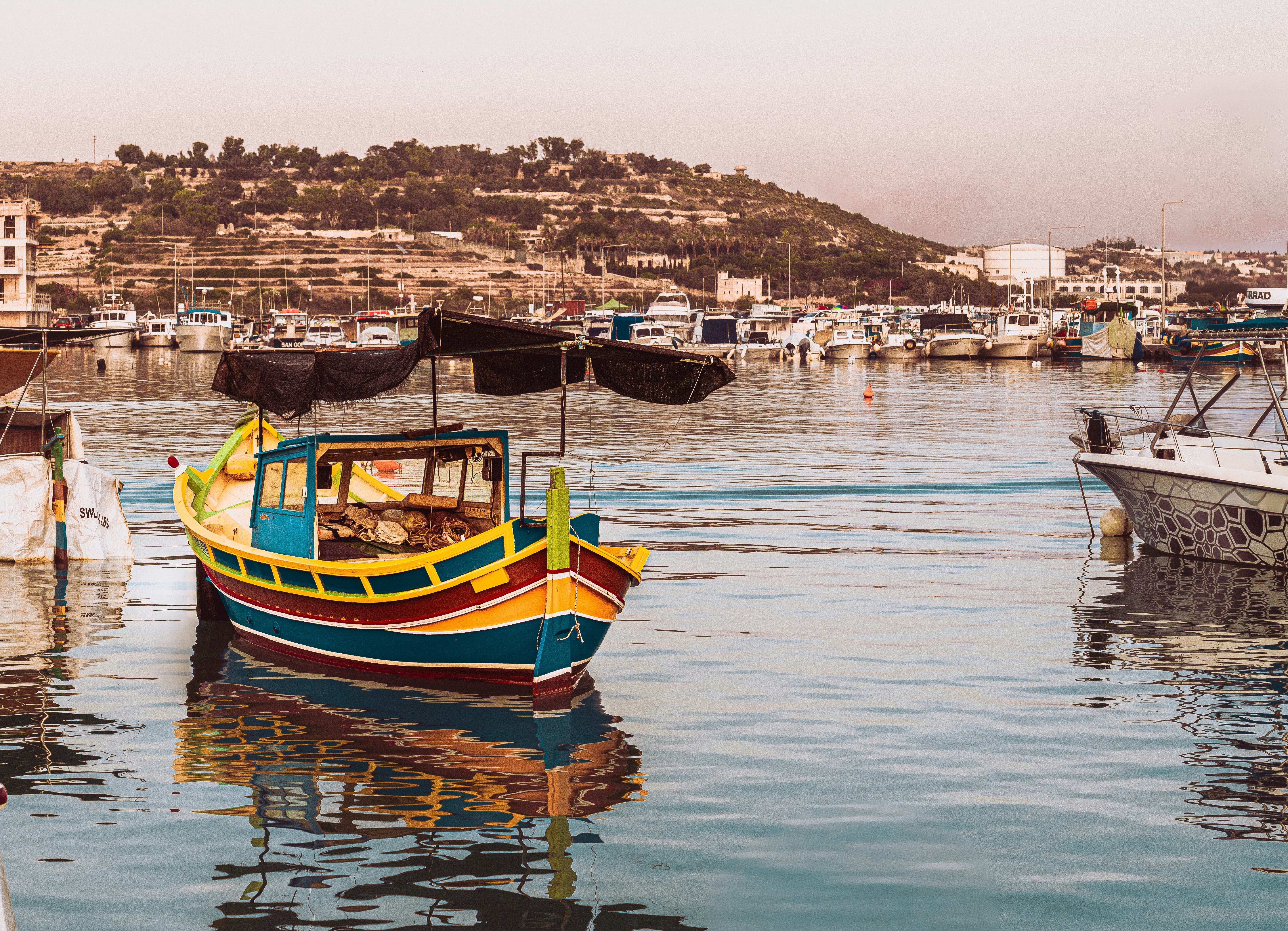 Colorful fishing boat anchored in a sunlit harbor