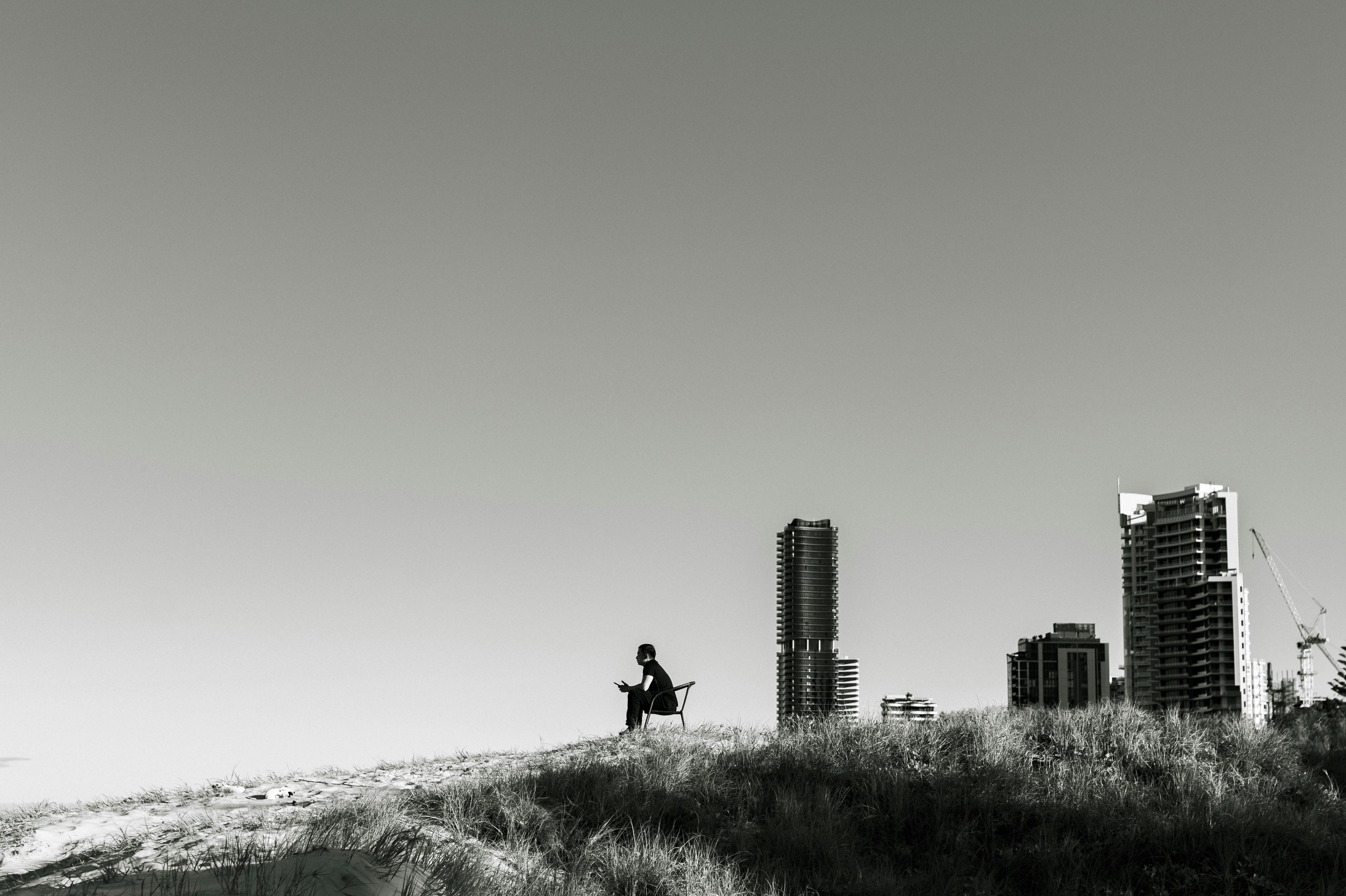 Dune and Crane Horizon: A Lone Worker Against a Growing City