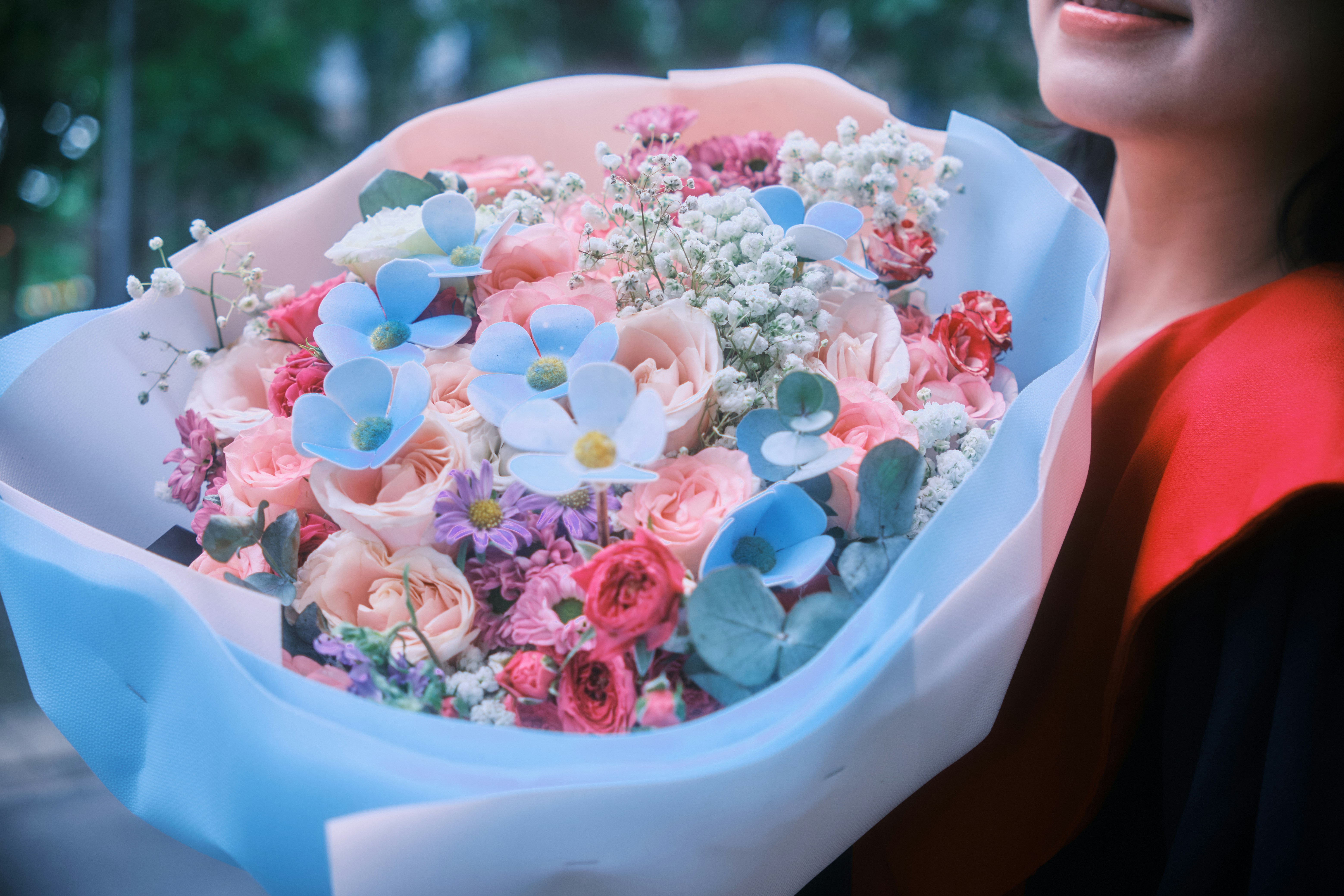 Bouquet of pastel blooms tucked beneath a red sleeve