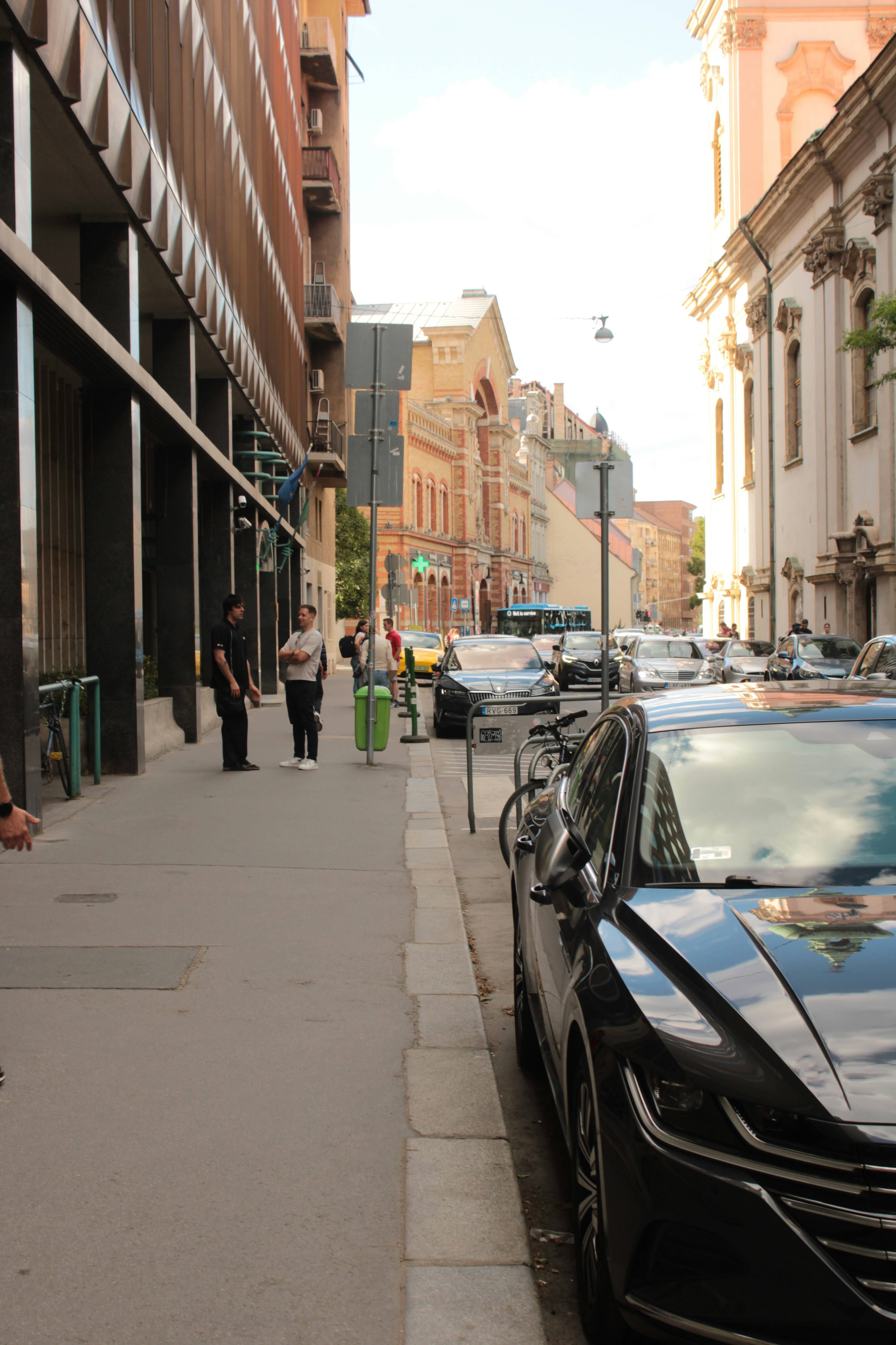 Street Pulse: A Black Car Framed by Historic Facades and Quiet Pedestrians