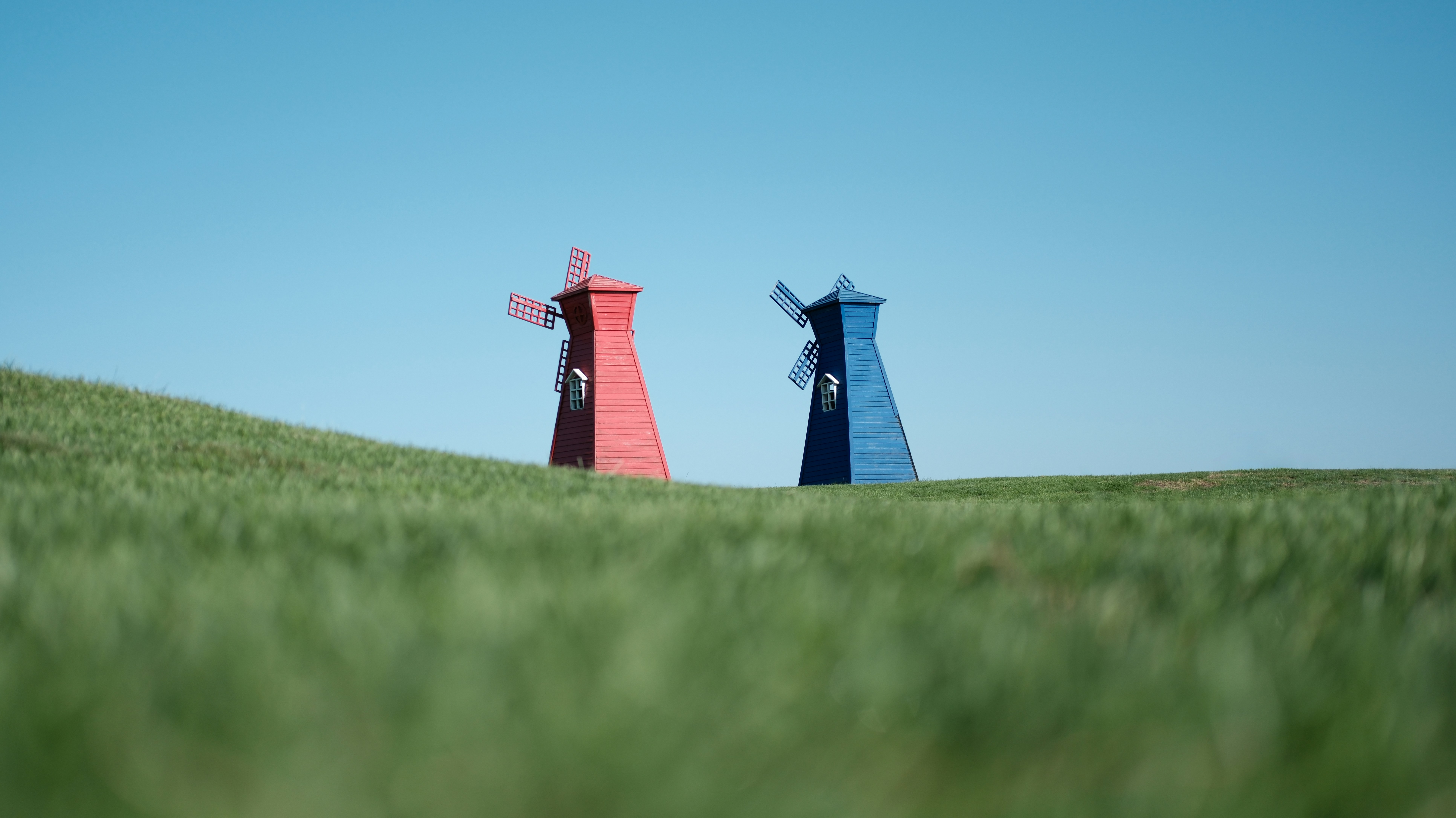 Twin Windmills on a Gentle Hill under a Clear Sky