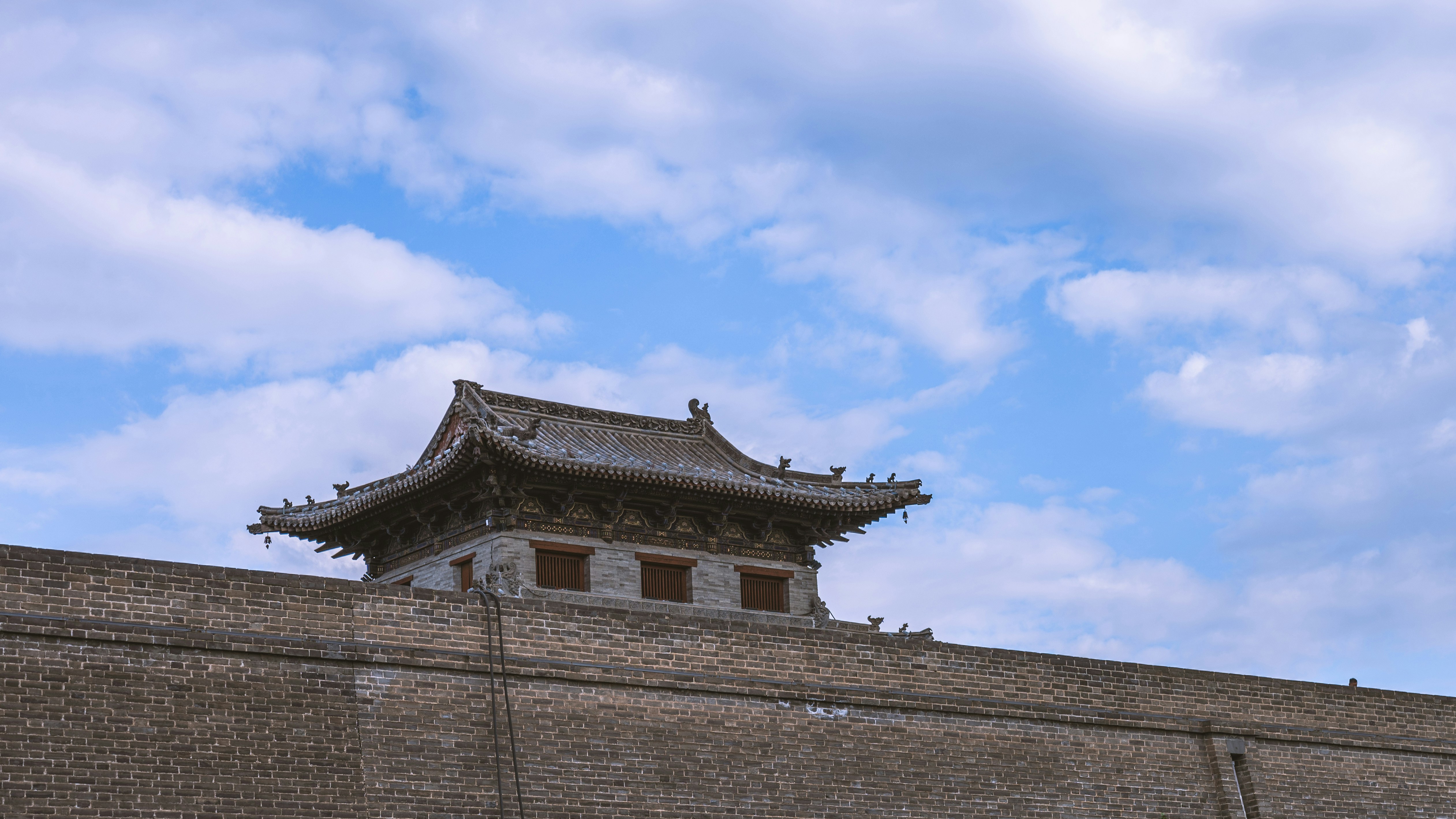 Moonlit Courtyard Gate: A Traditional Chinese Structure Rises Over a Rustic Brick Wall