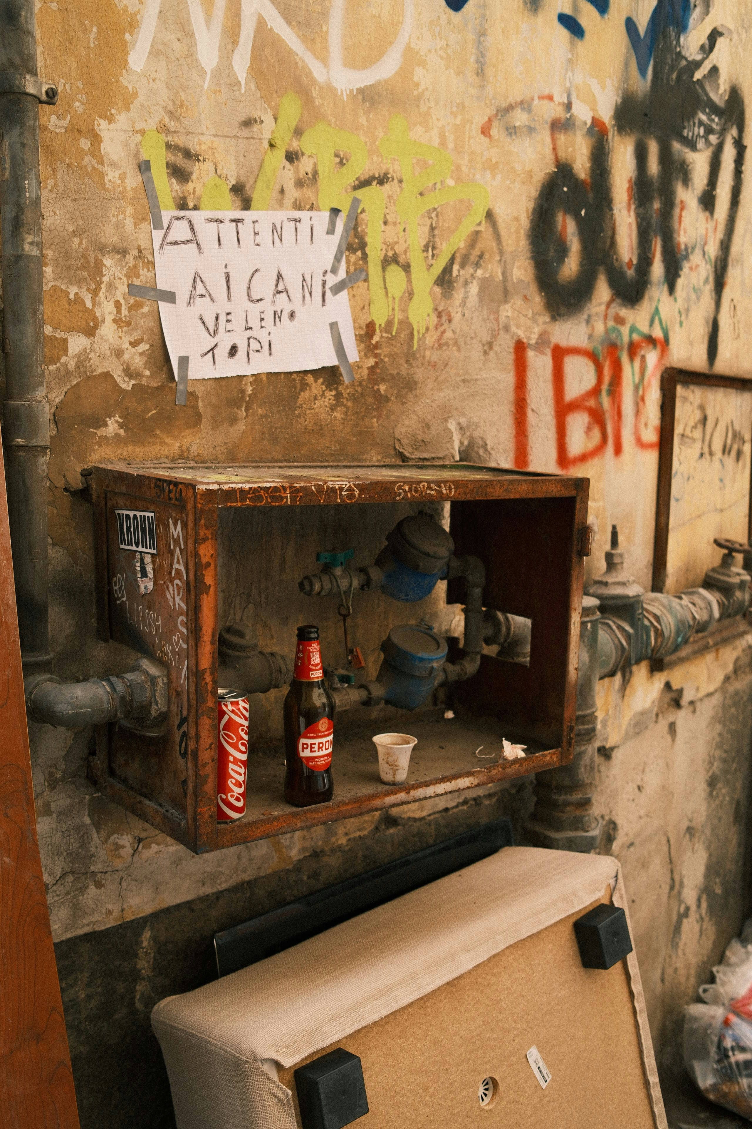 Graffiti-Stamped Nook: A Quiet Molten Scene of Bottles and Pipes