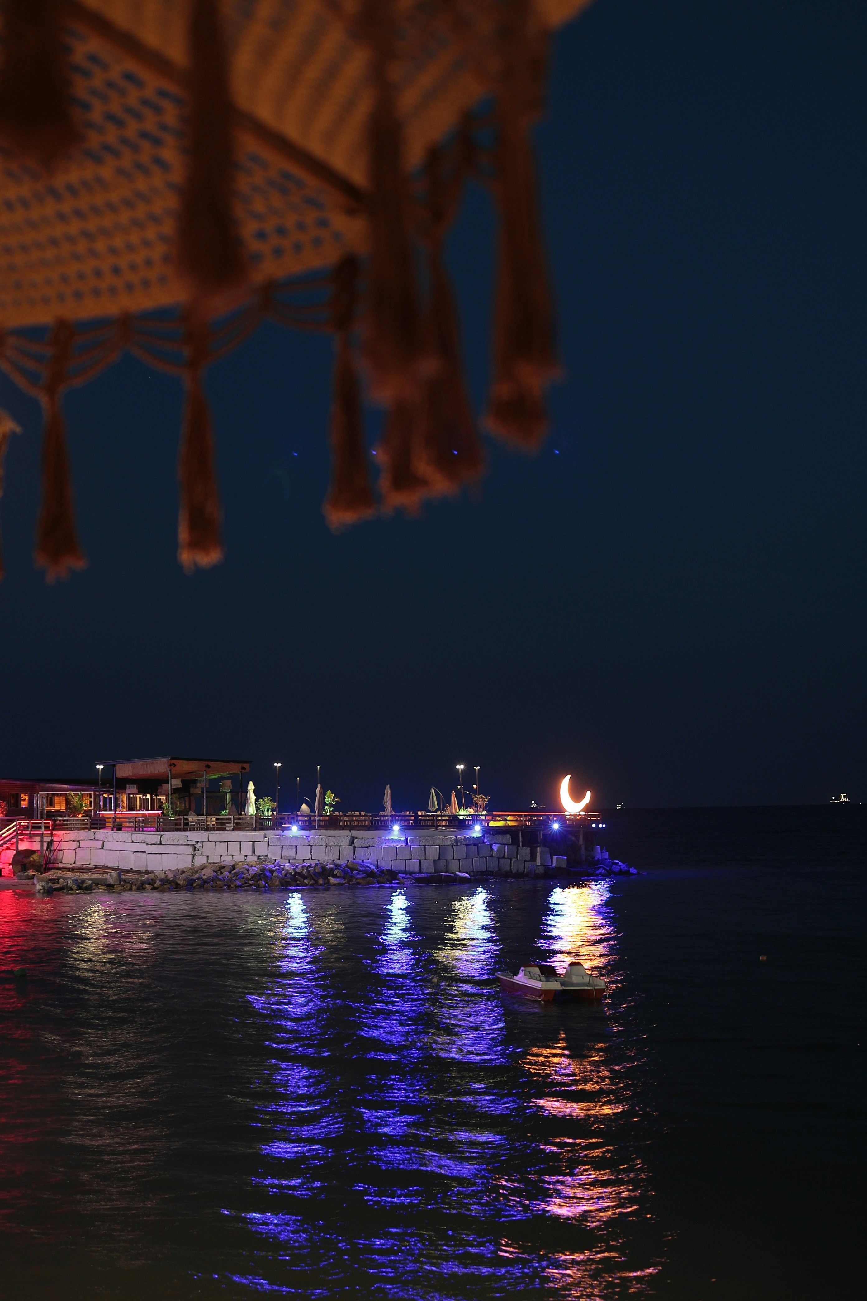 Moonlit Crescent over the Pier: Night Reflections on Quiet Waters