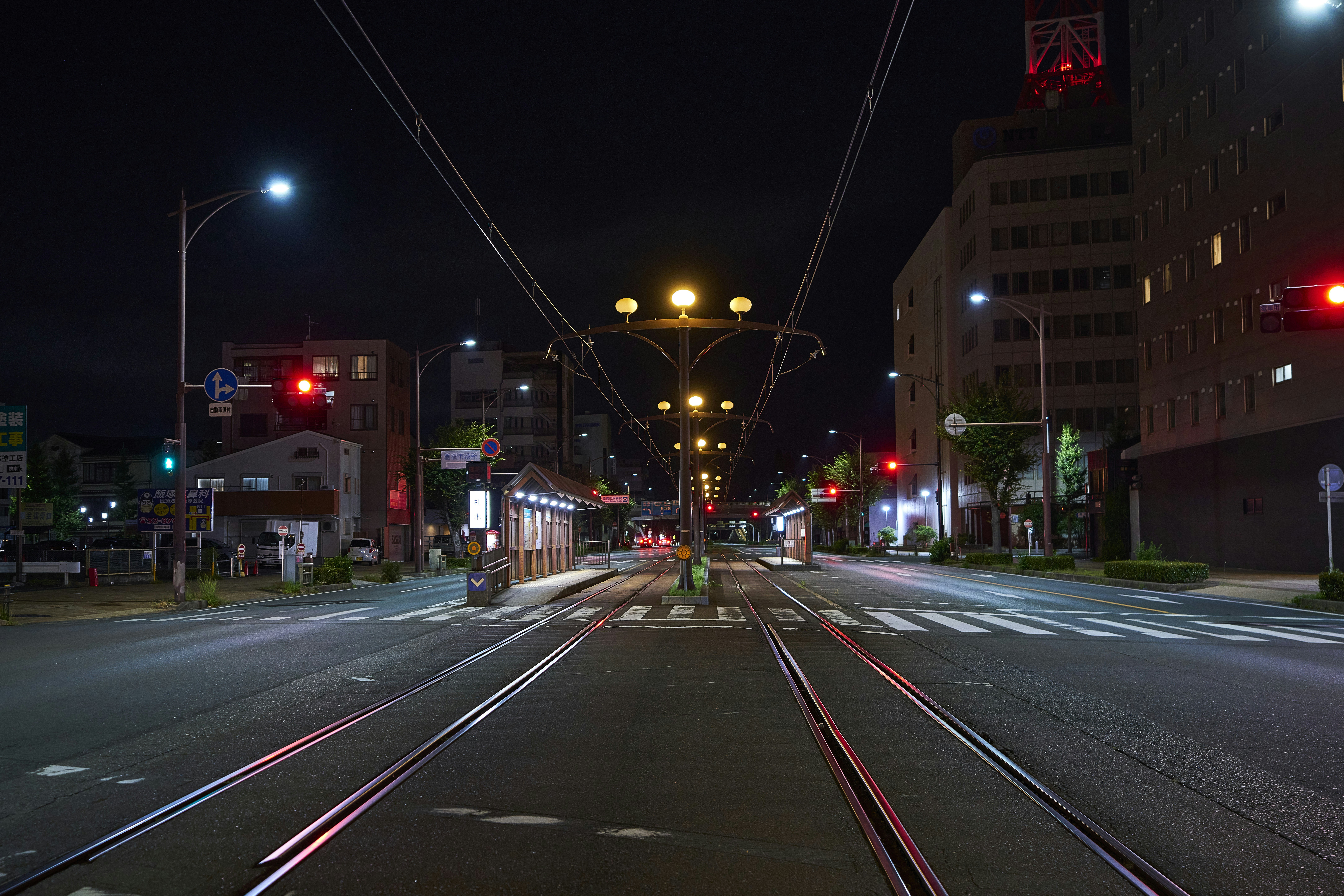 Night tramway converging at the quiet city heart