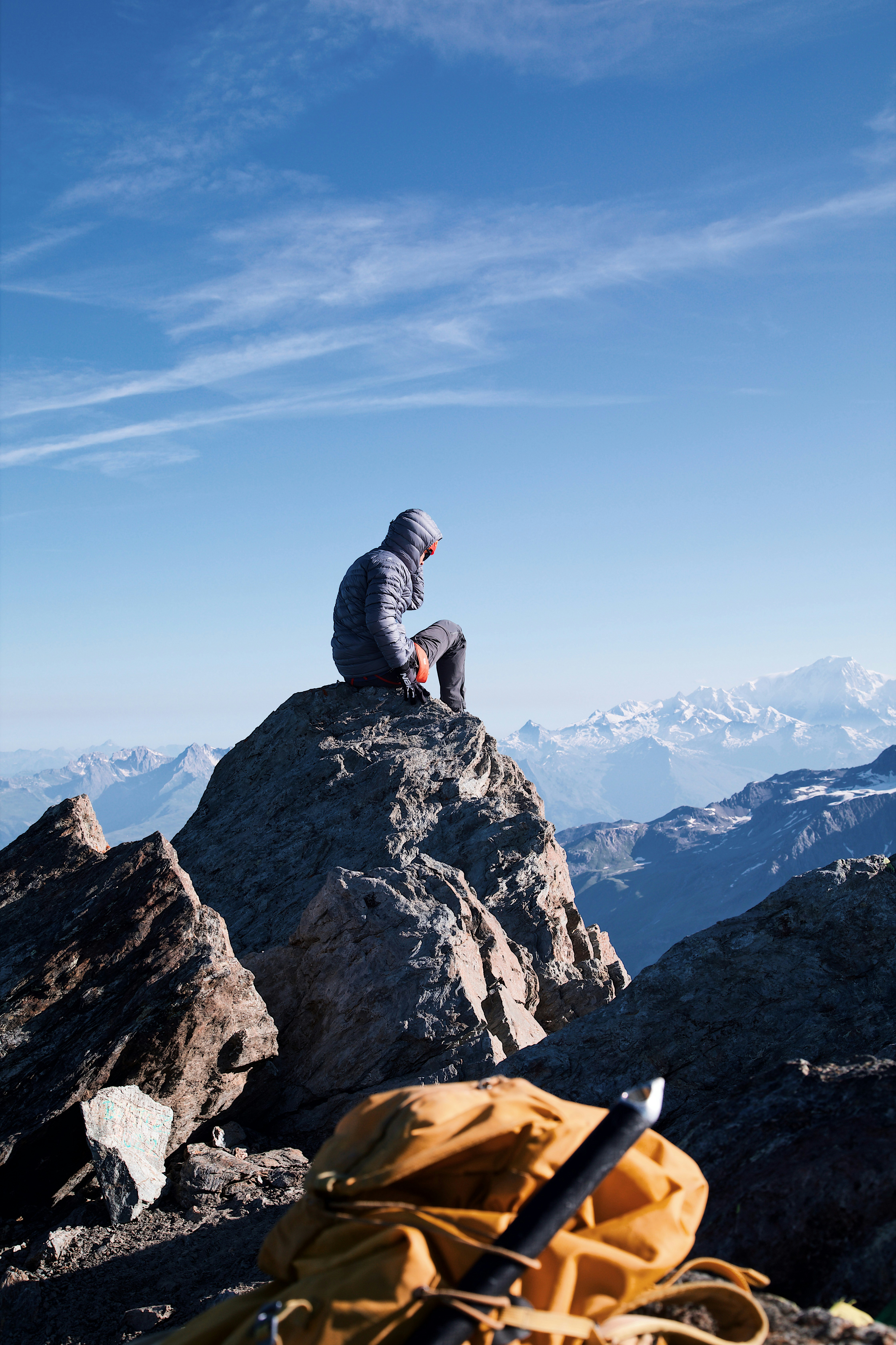 Above the World: climber perched on granite, with alpine panorama behind