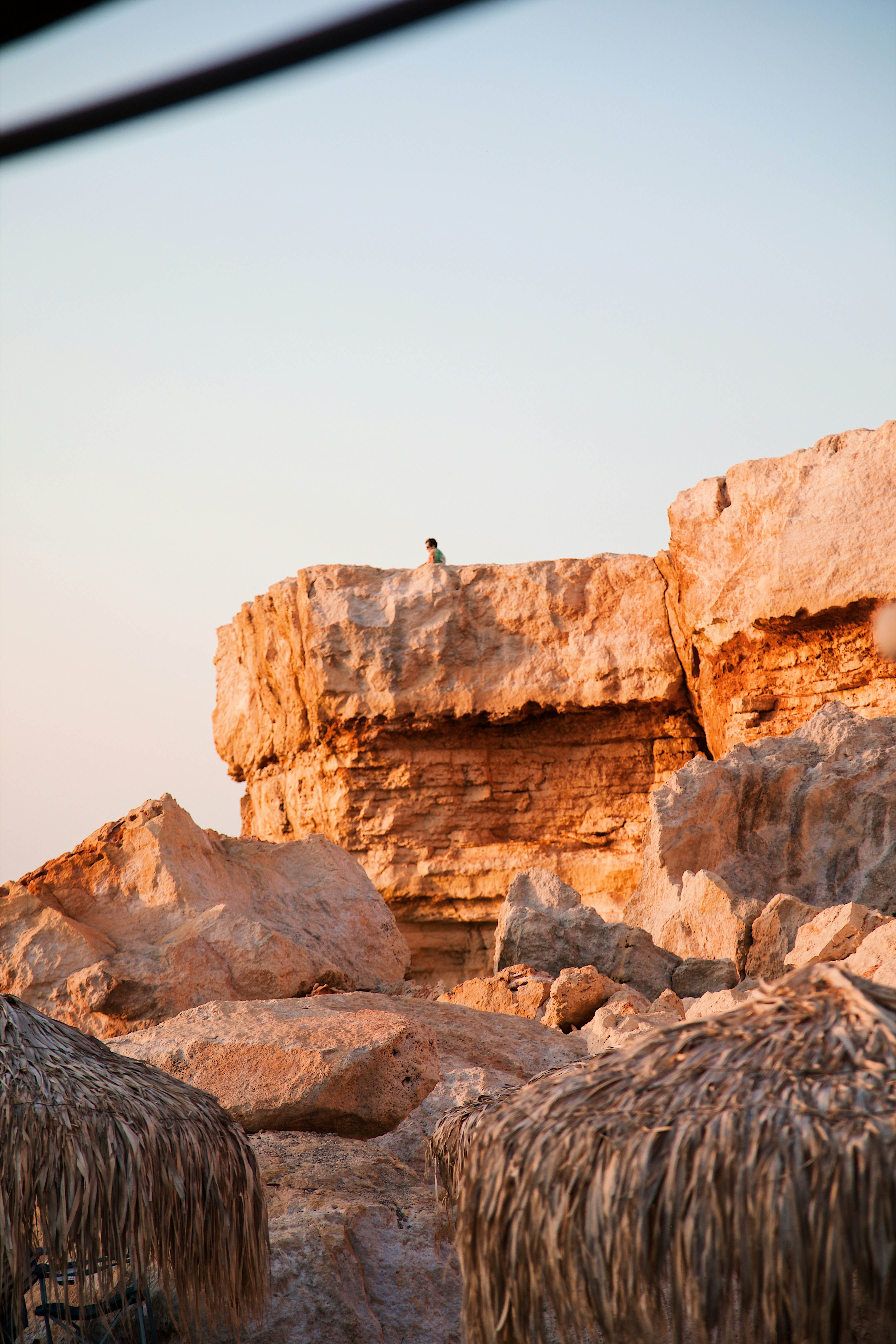 Lone Eyed Sentinel on a Cliff: A Hidden Figure Above the Desert Rocks