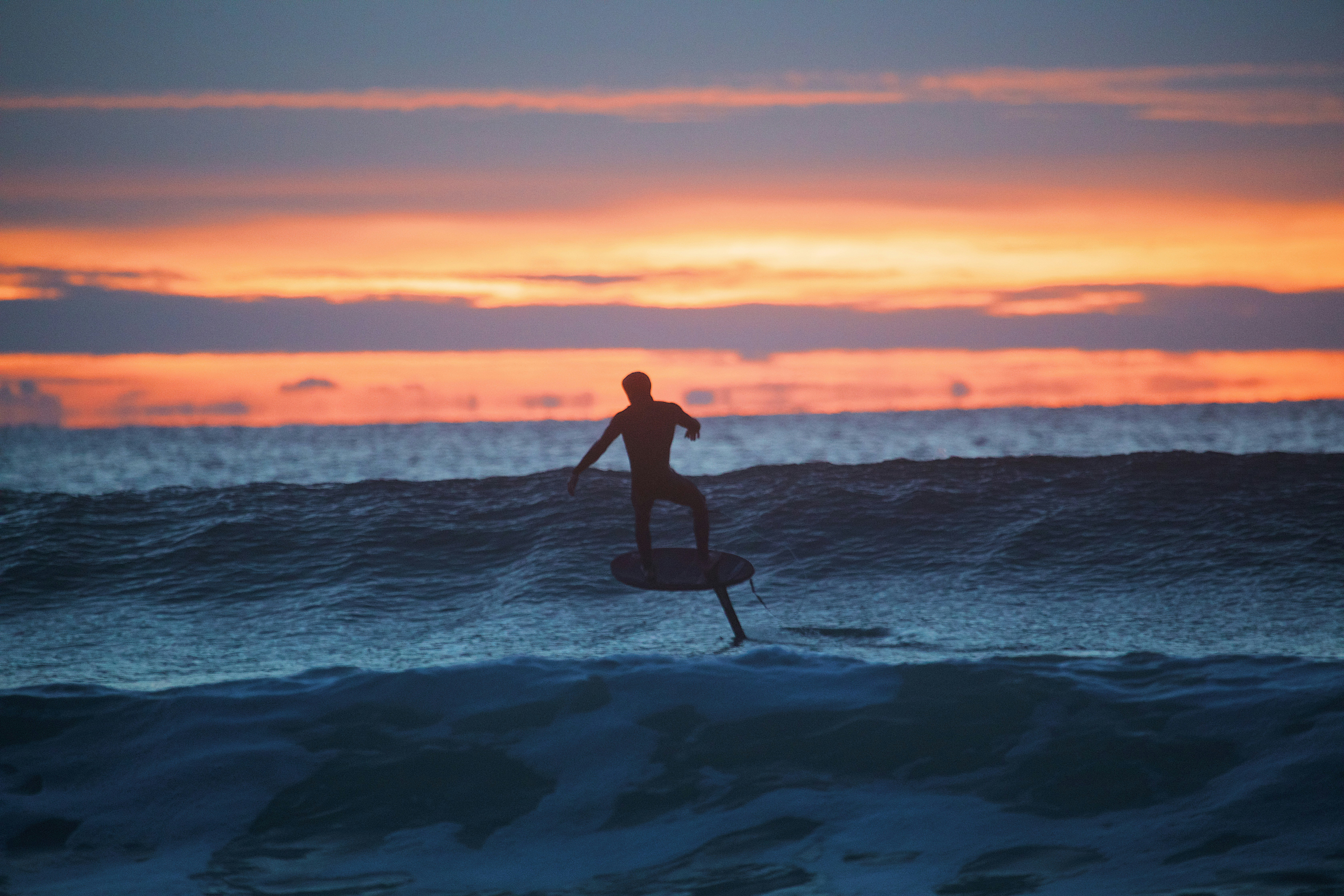 Silhouette on the Crest: A Surfer at Sunset